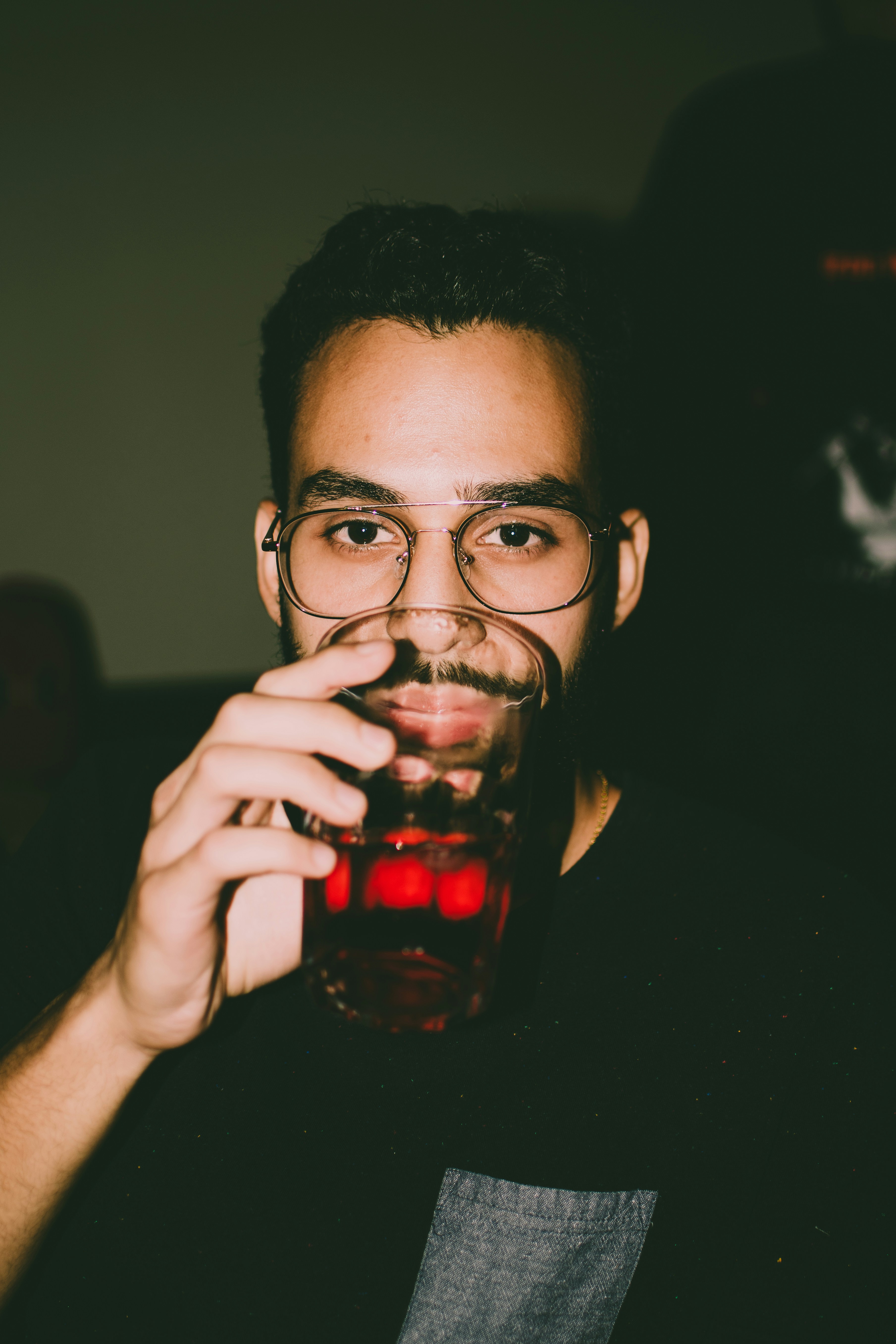 Guy in a blue shirt with glasses drinking cranberry juice