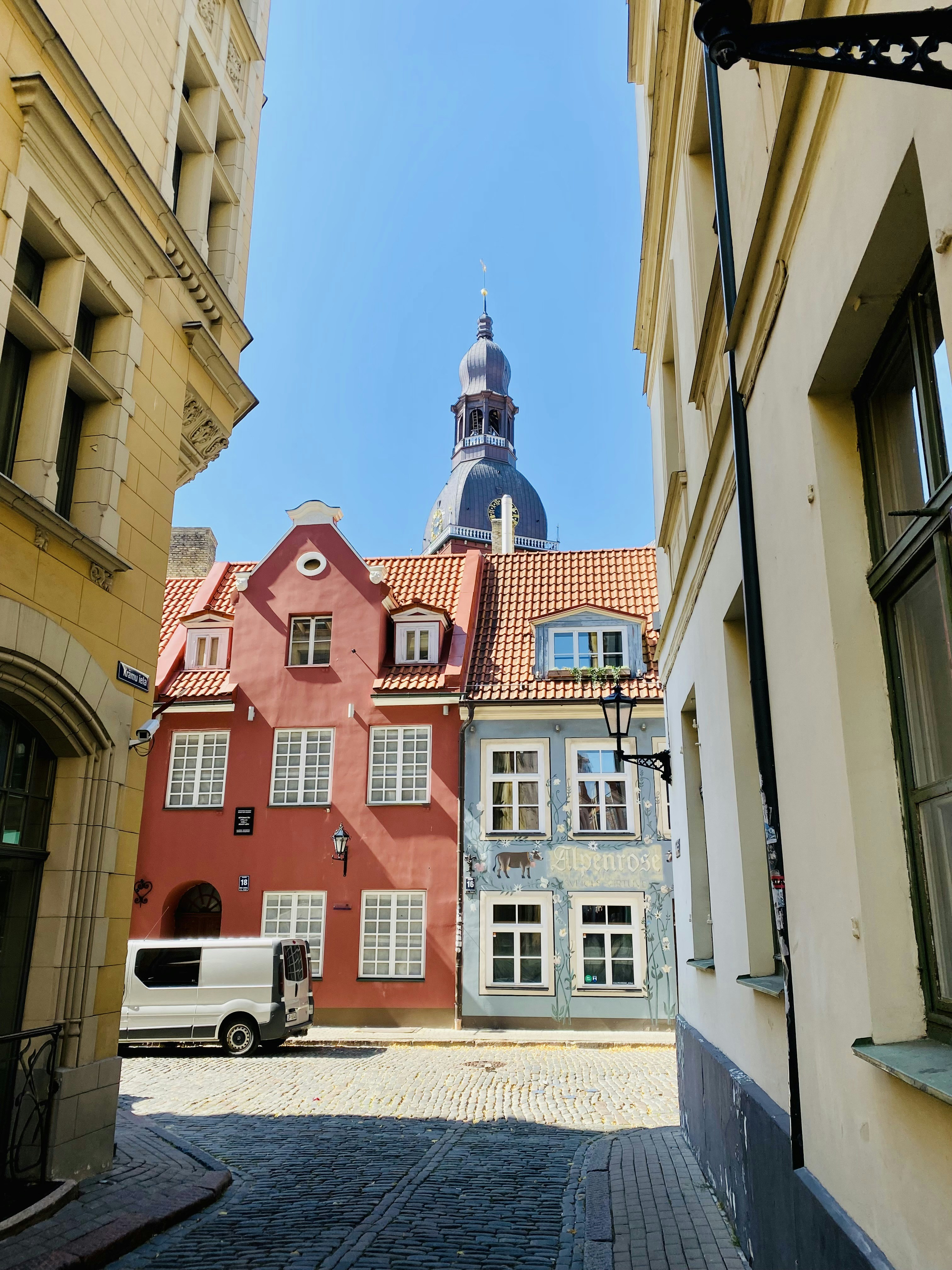 Charming street view showcasing colorful historic buildings and a striking dome in the background. The scene captures the essence of a vibrant urban landscape.