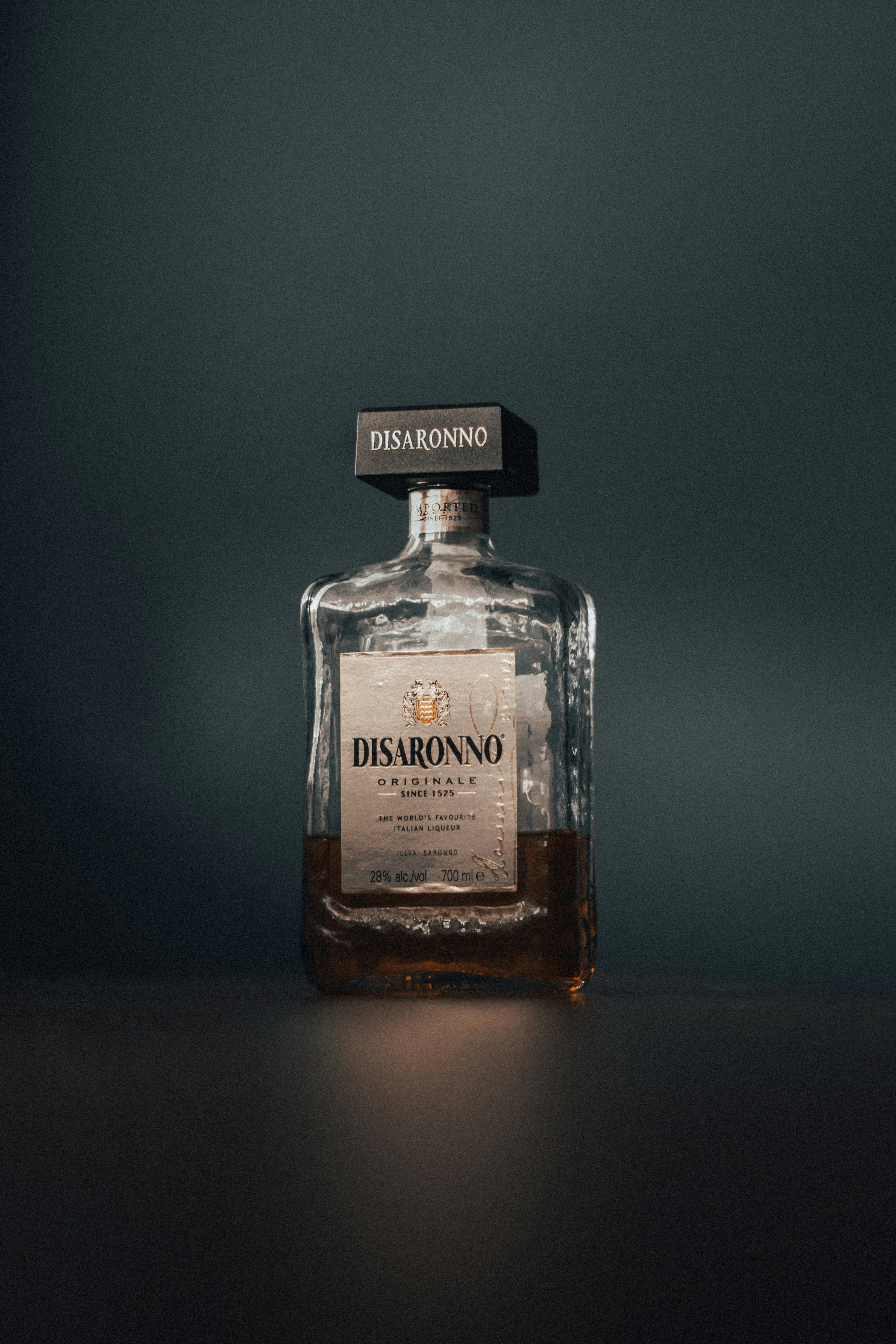 A bottle of disarronno sitting on a table photo – Free Alcohol Image on ...