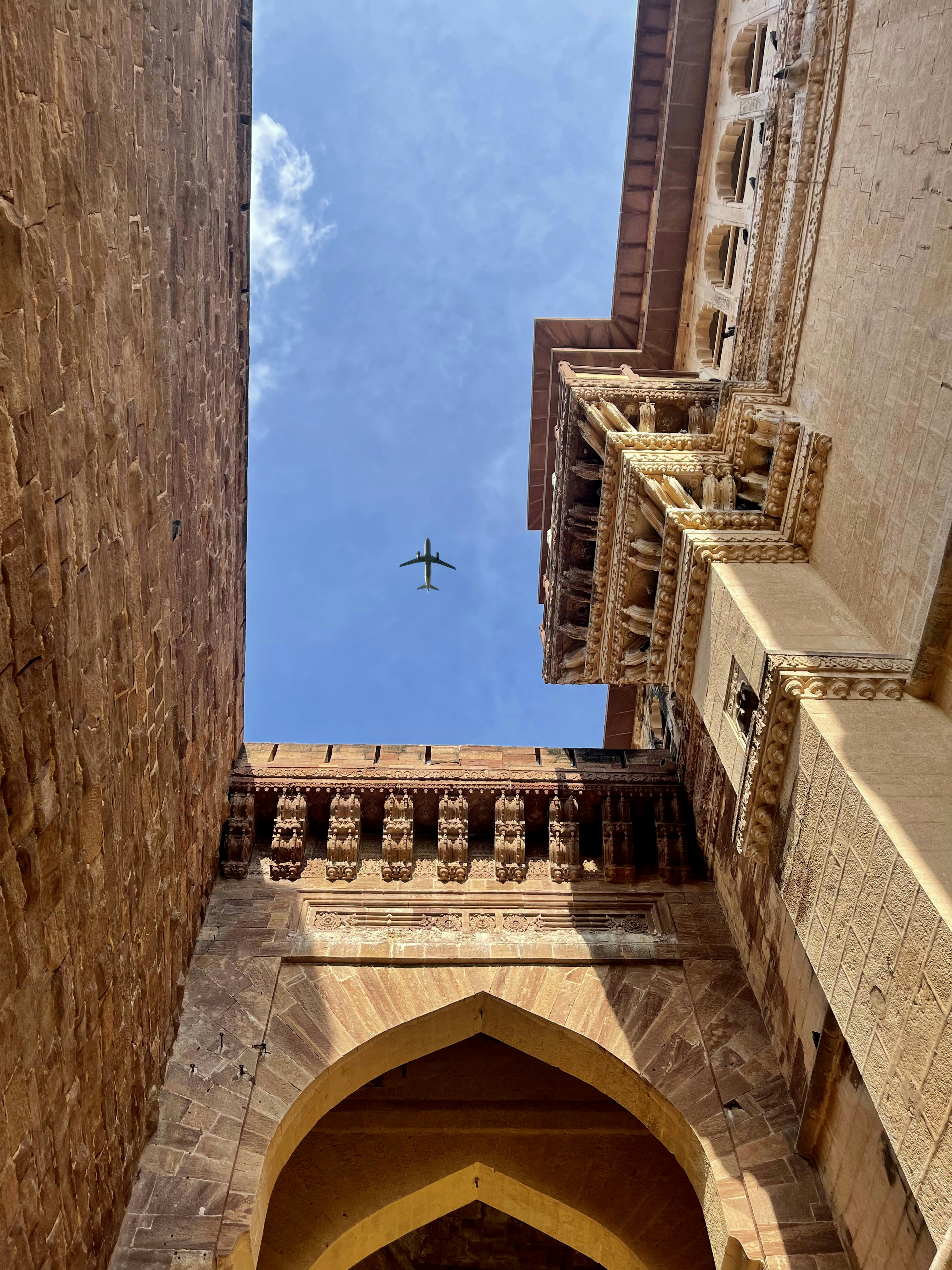 Skyward Between Ancient Walls: An Airplane Between Archways