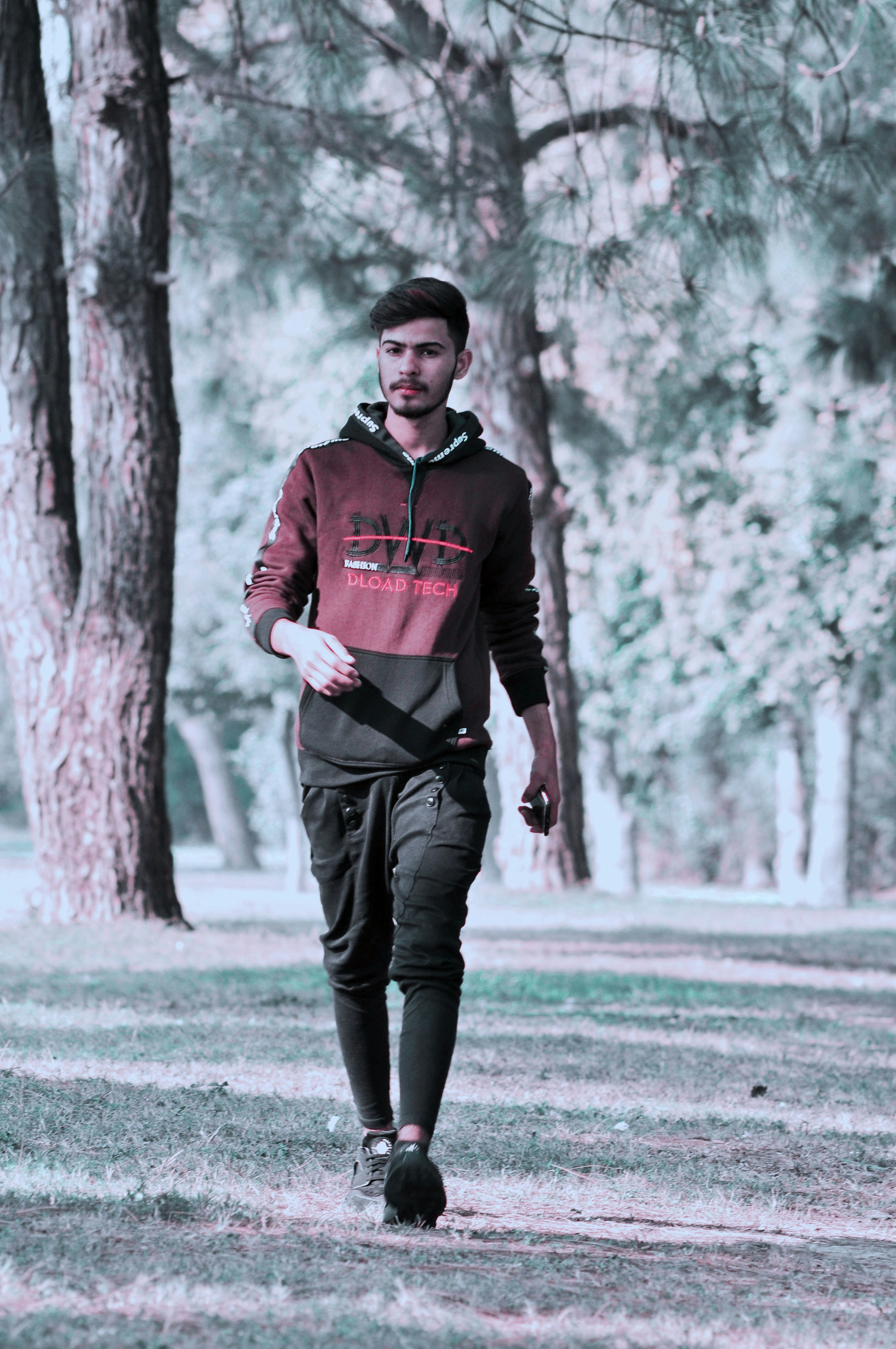 man in red and black zip up jacket standing on forest during daytime