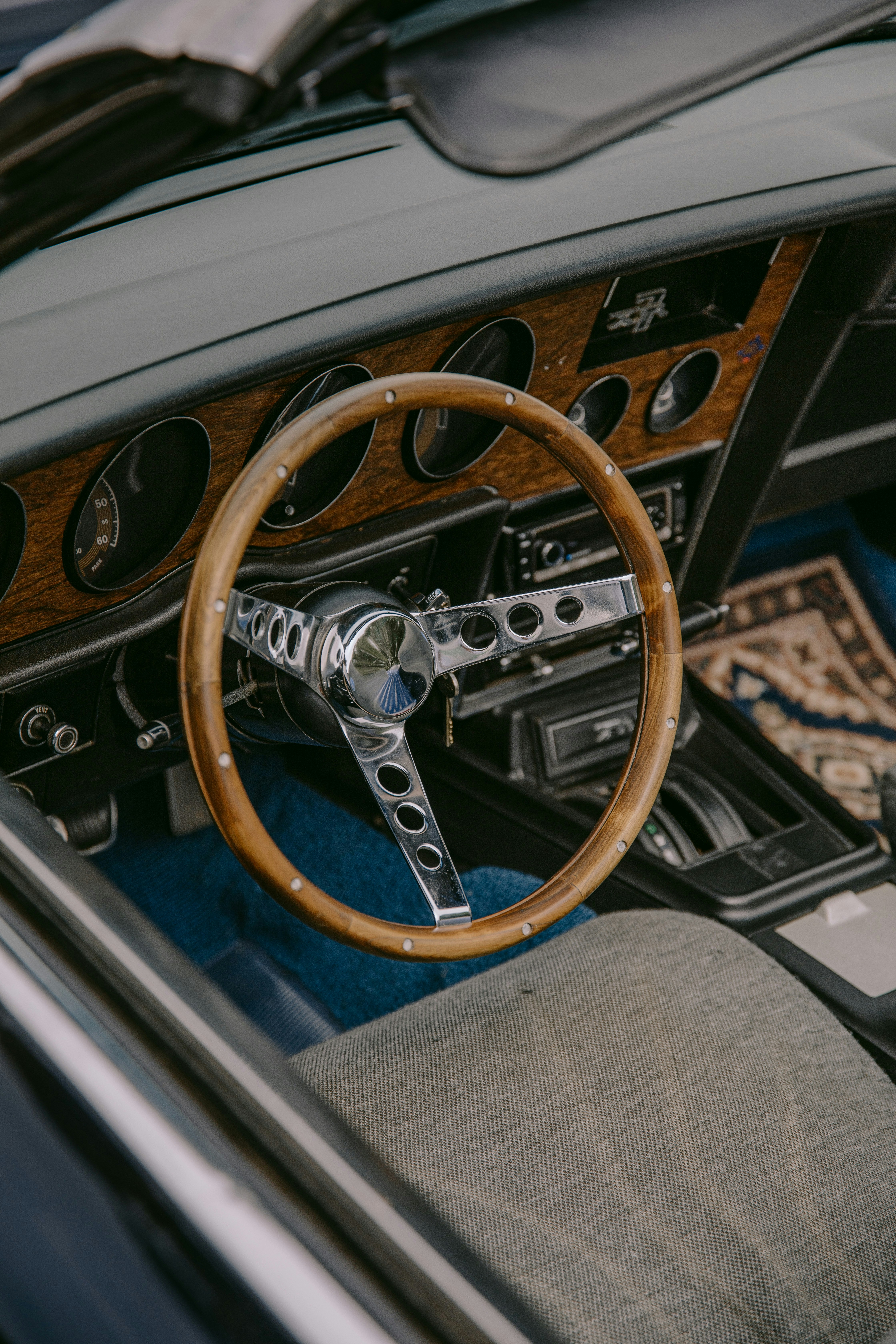 Timber-spoked cockpit: a vintage car's wooden dashboard and chrome detail