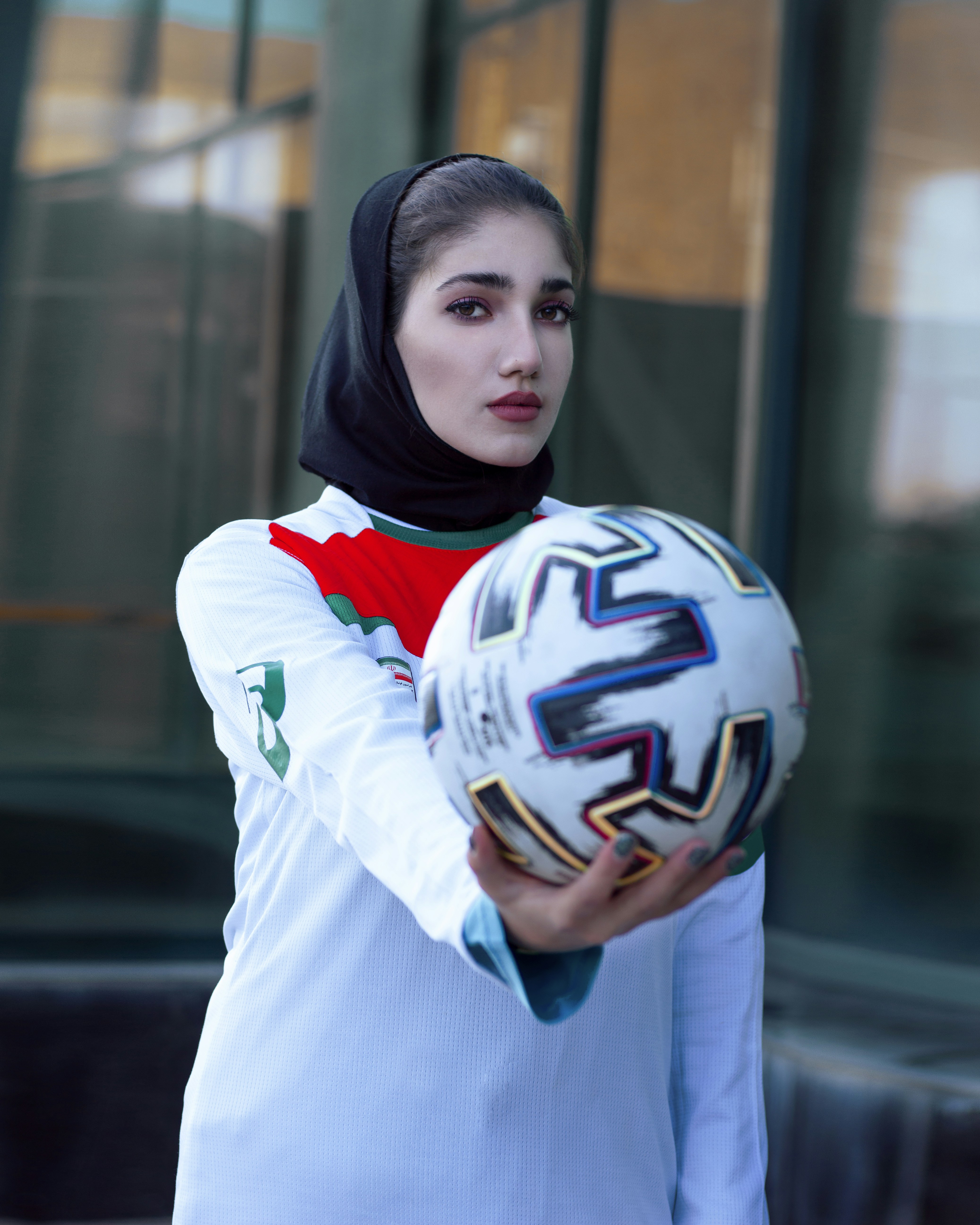 Graceful Reach: A Hijab-Clad Player Extends a Soccer Ball