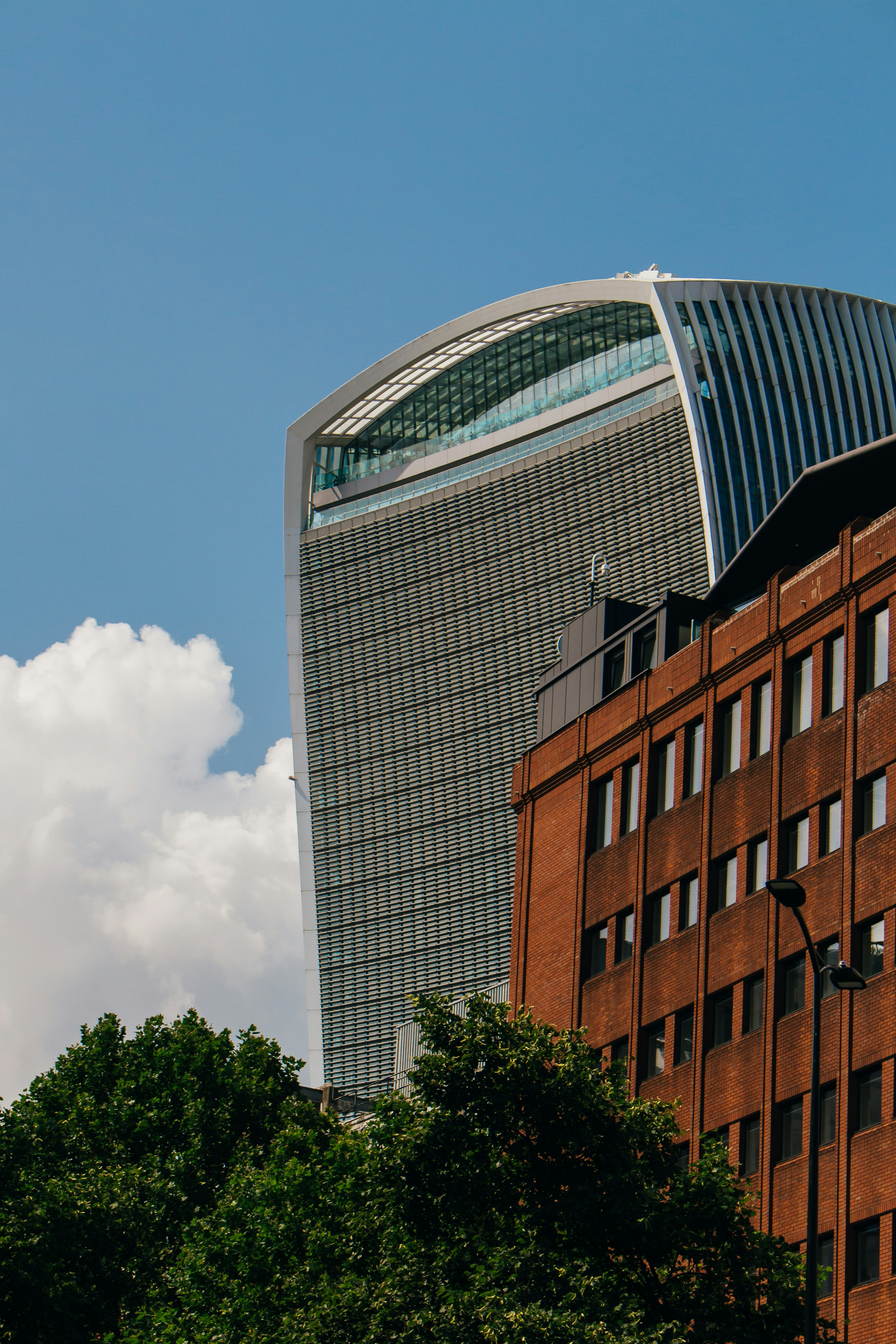 Brown and gray concrete building under white clouds and blue sky during ...