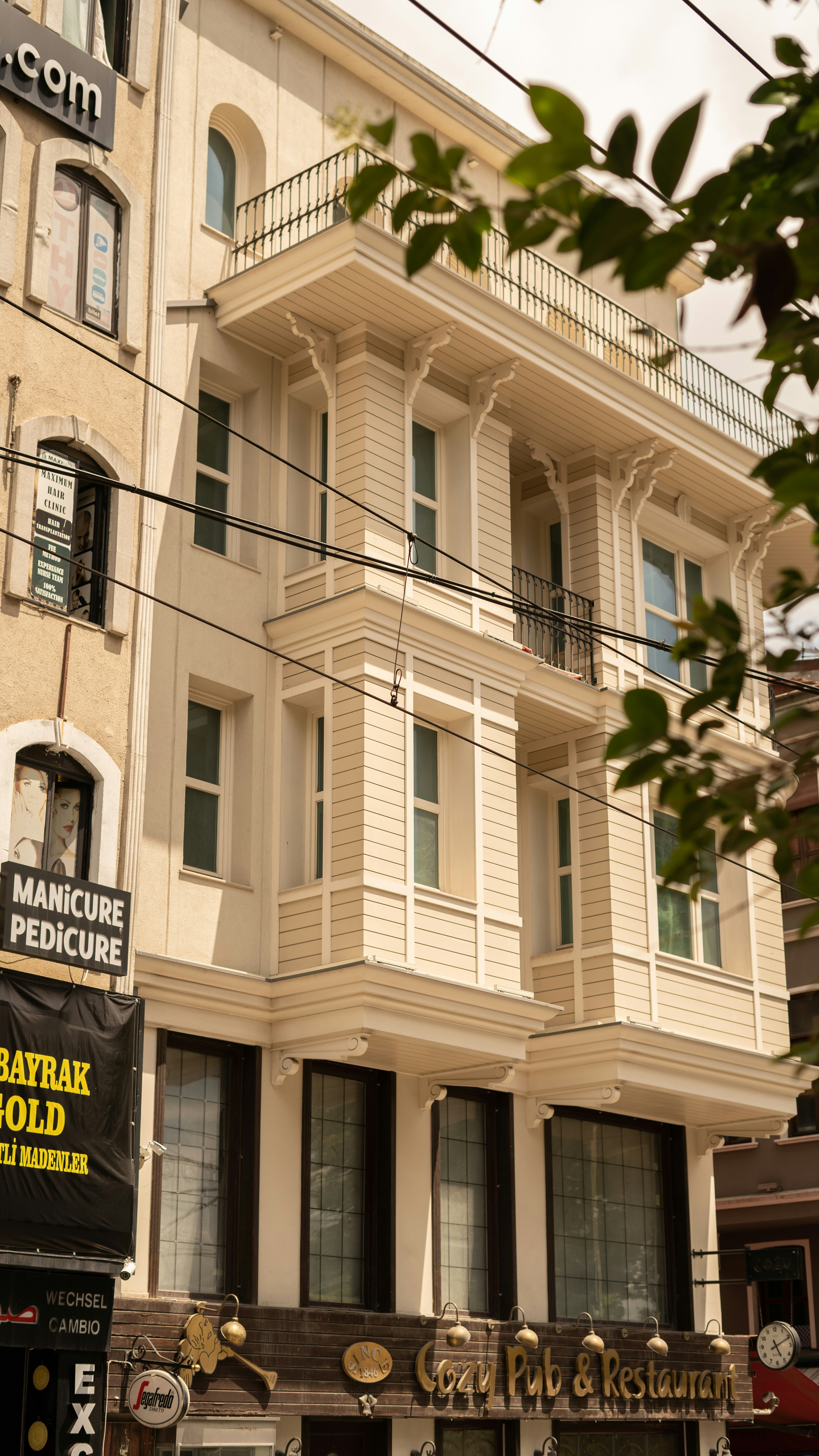 Sunlit Neoclassical Corner: Balconies, Columns and Street Signage