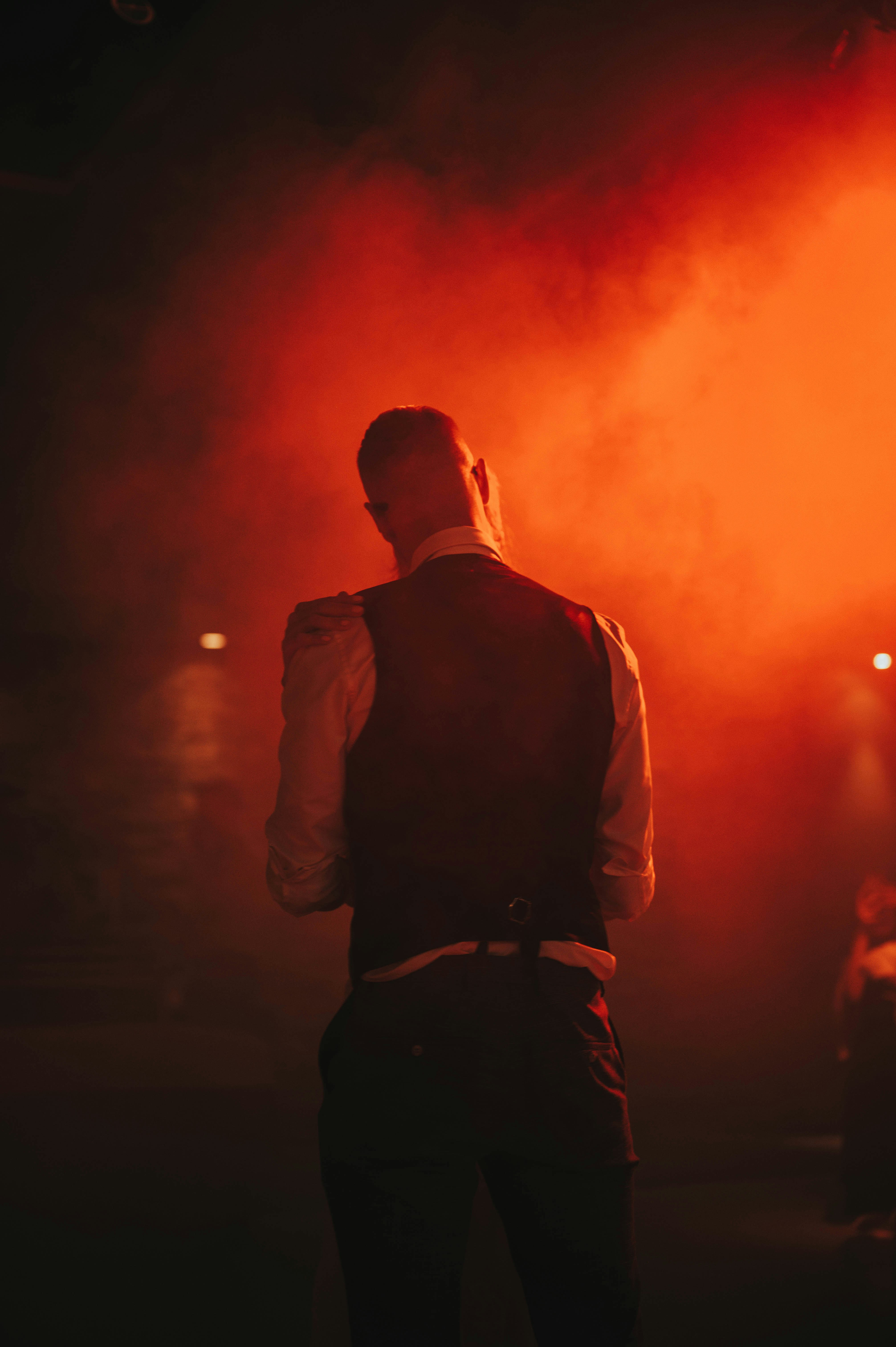 Backlit Performer in Ember Hue at a Dim Stage