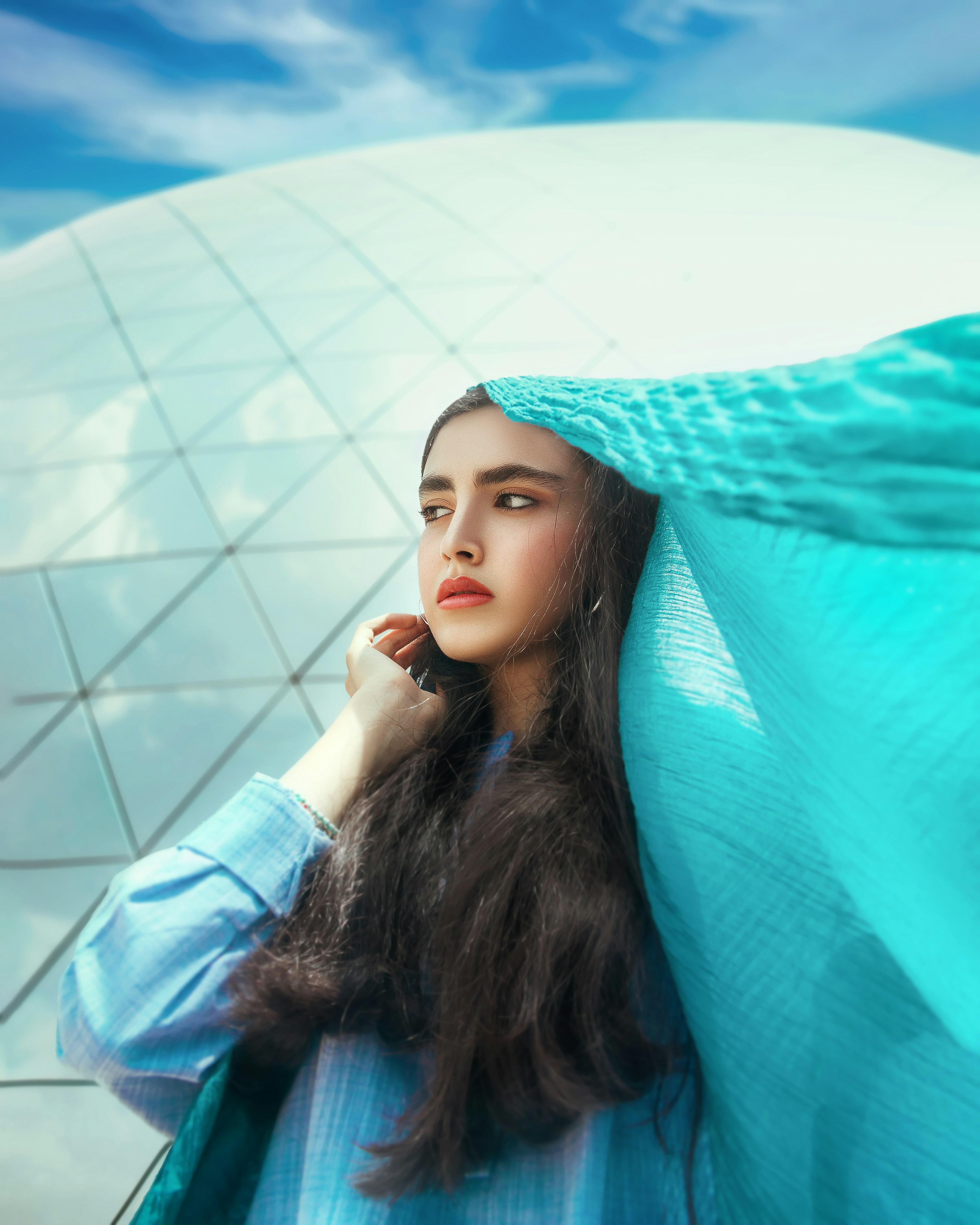 Turquoise Veil Against a Geodesic Glass Dome: A Portrait of Quiet Gaze