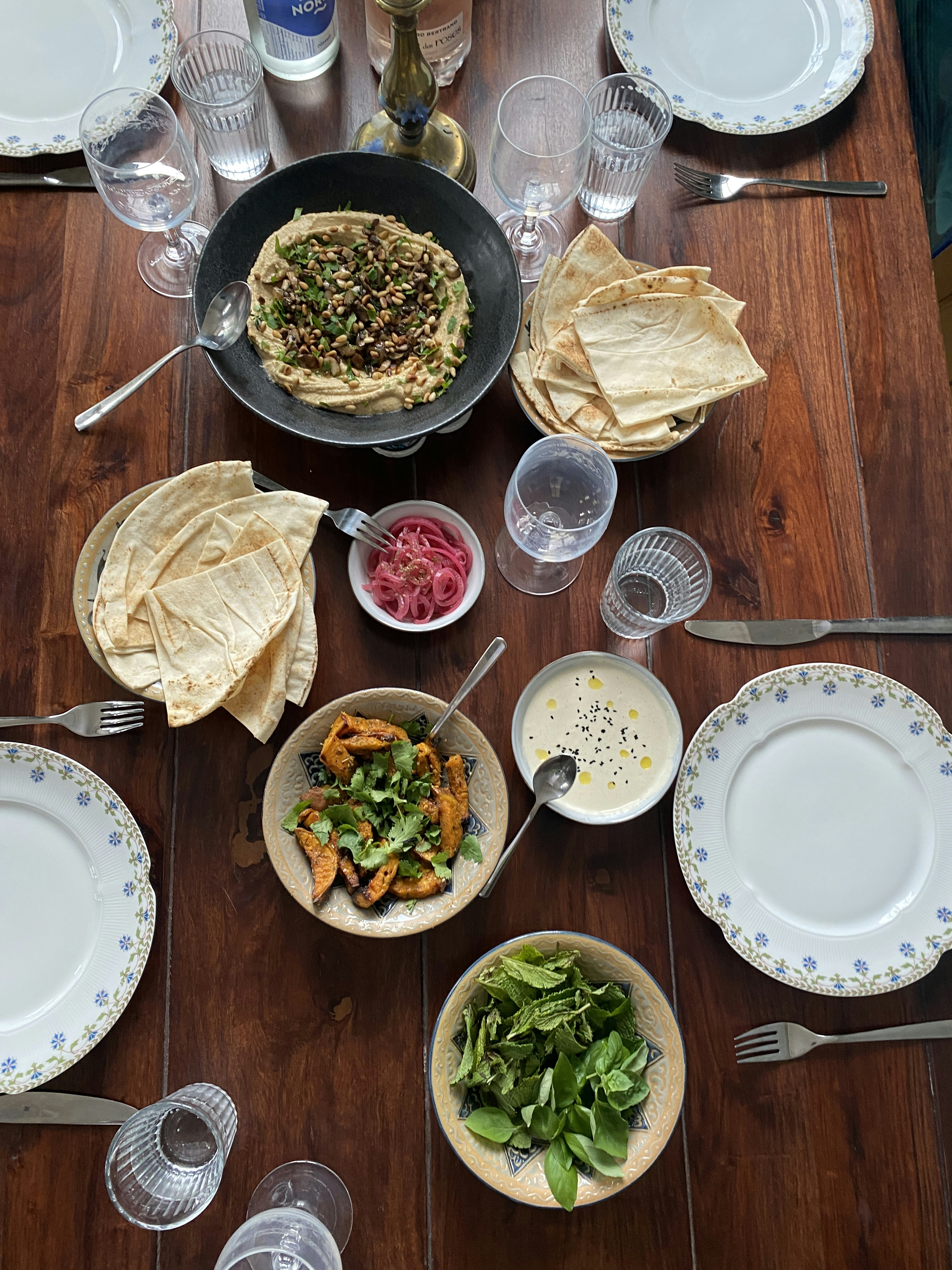 Skillet Hummus Crowned with Nuts, Pita Crescents, and Fresh Greens