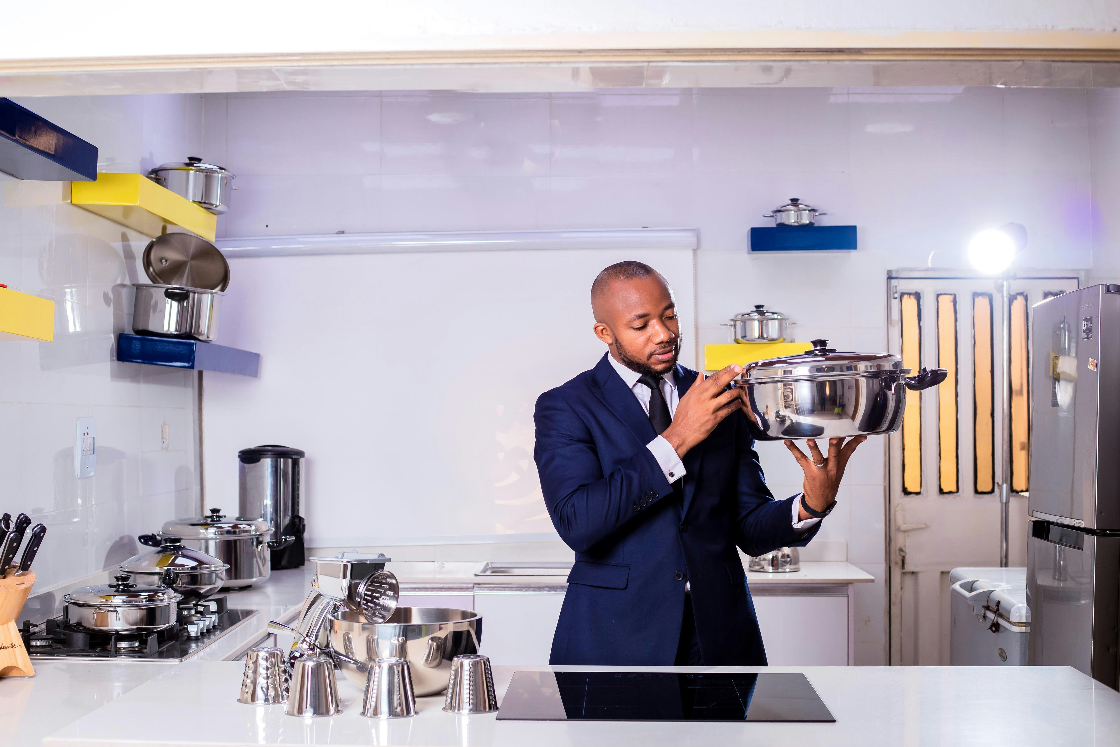 Homme en costume noir tenant une marmite en acier inoxydable photo ...