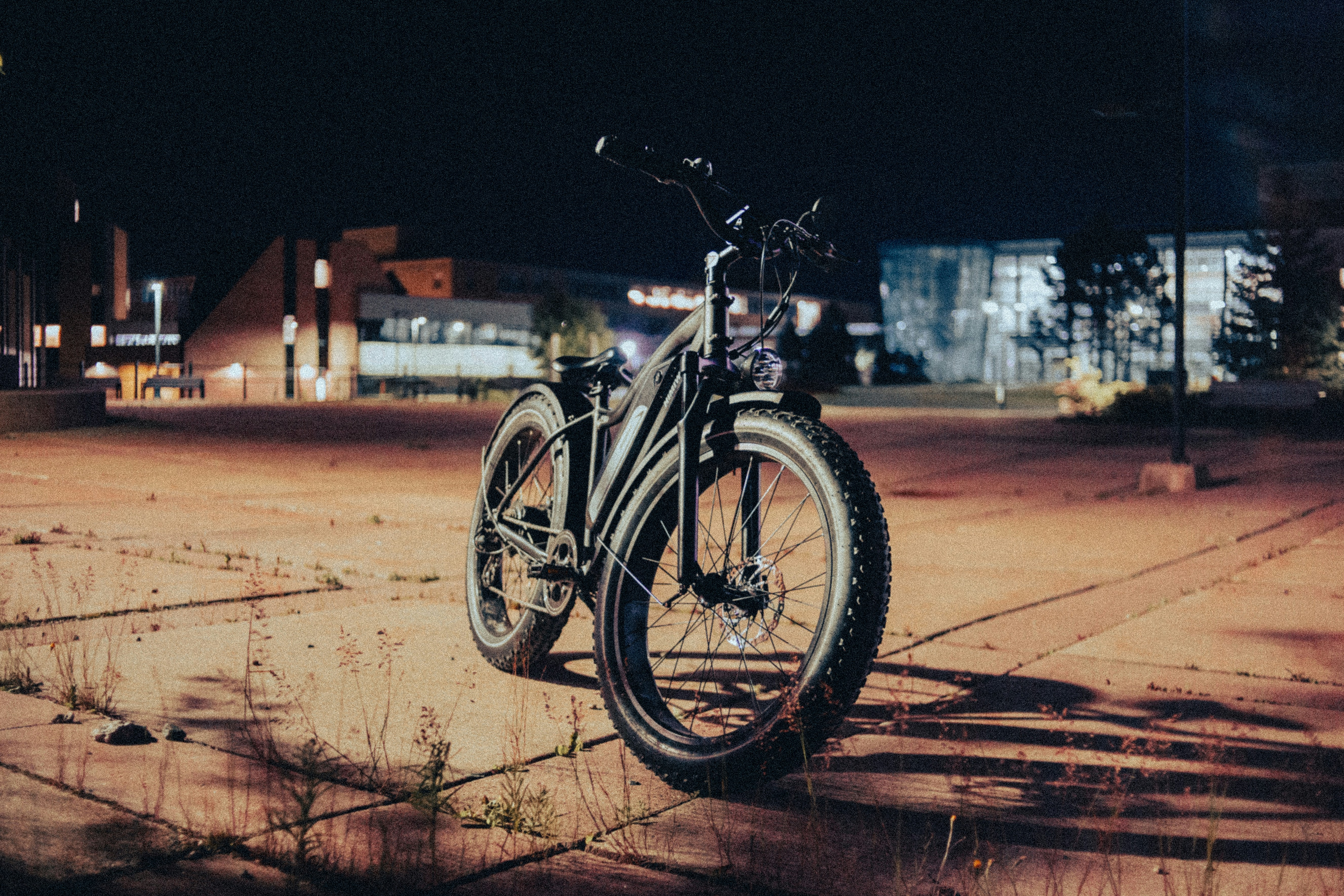 black and silver cruiser motorcycle on brown concrete floor during night time