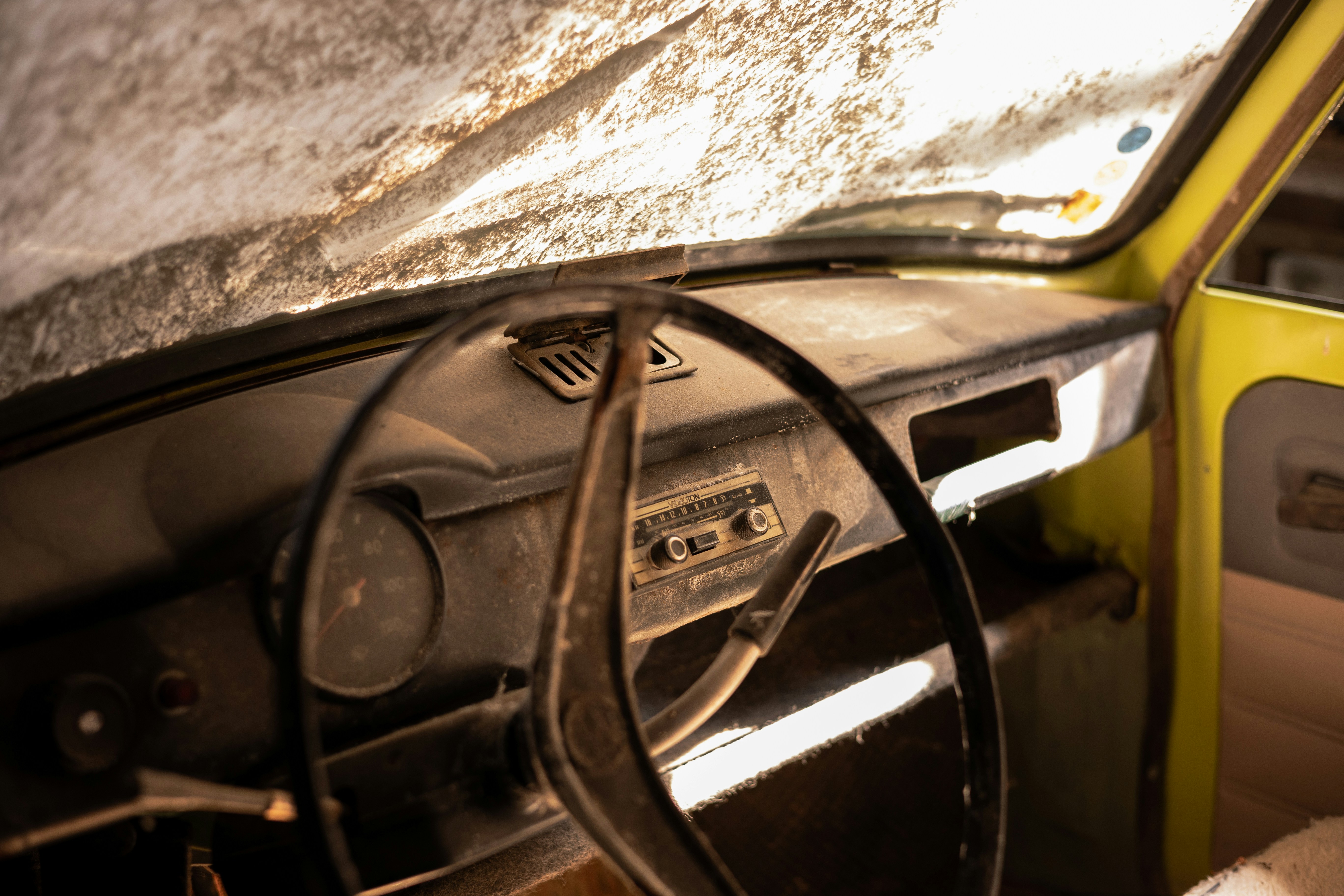 Lime-Yellow Relic in Snow: A Dusty Car Cockpit Frozen in Time