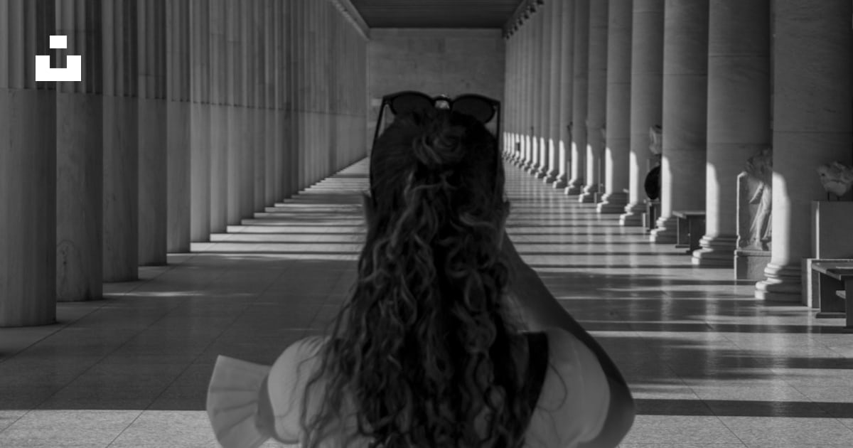 Foto Foto En Escala De Grises De Una Mujer Vestida De Blanco Sentada En