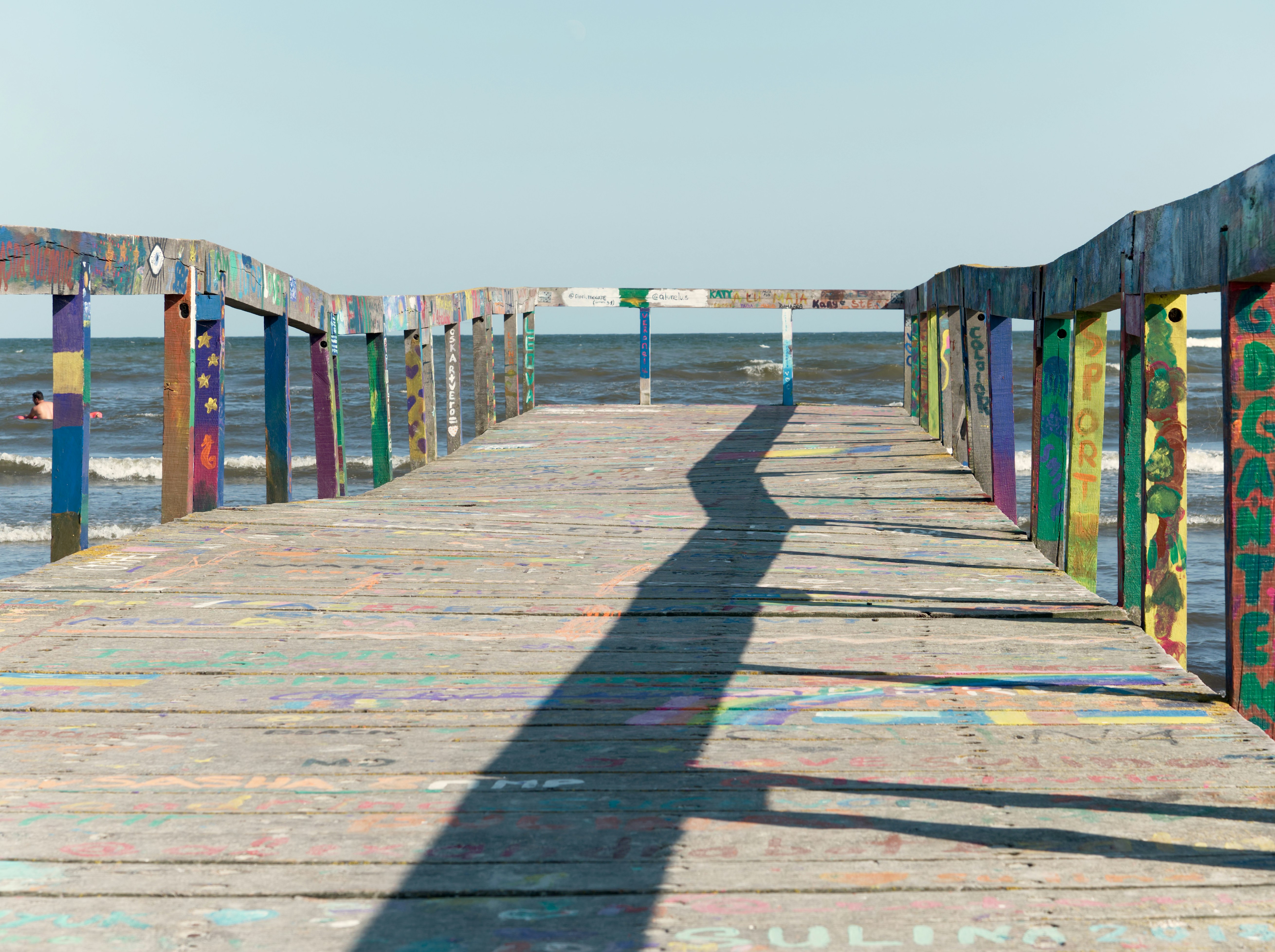 Graffiti-Laced Pier Extends Toward a Calm Sea