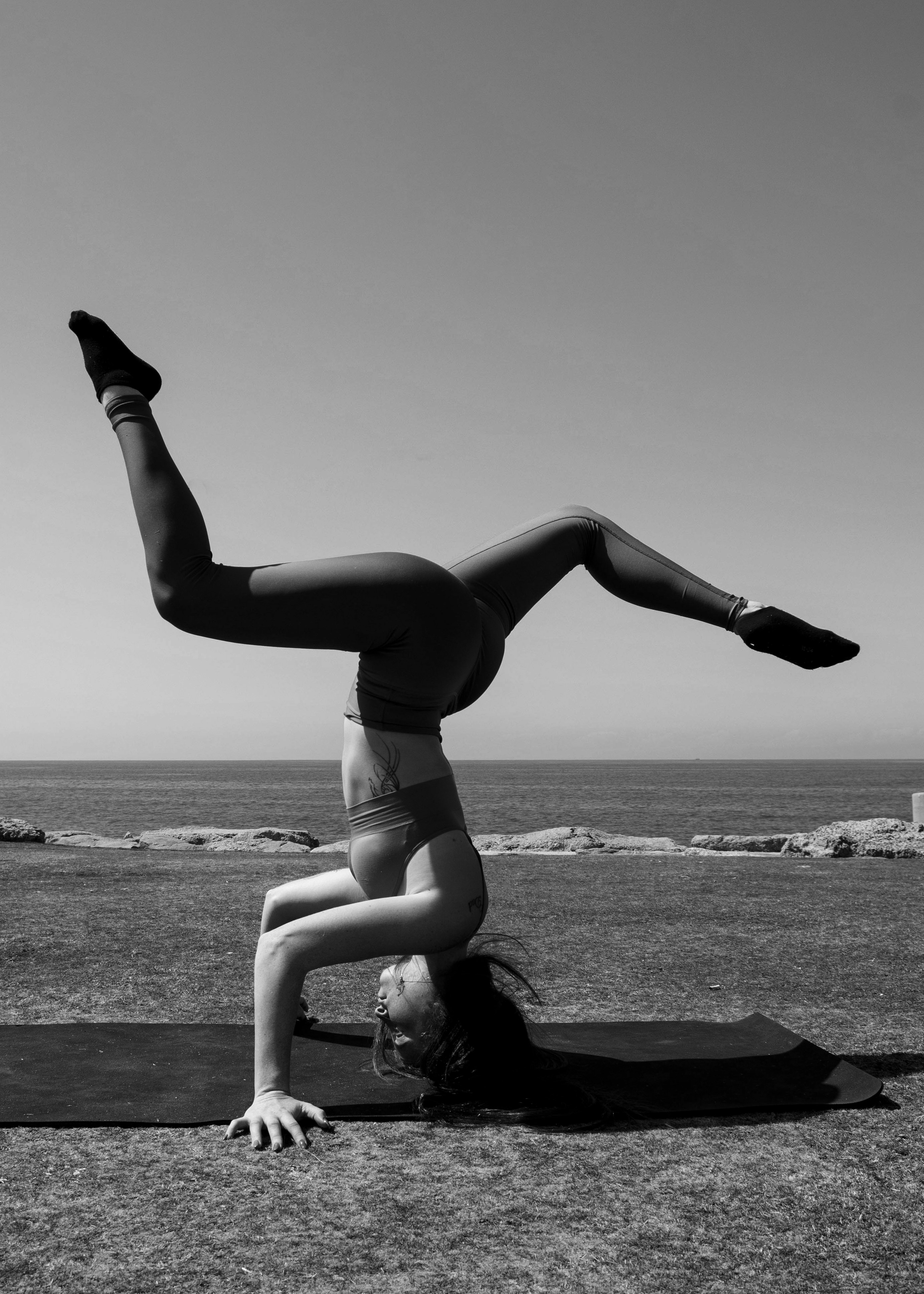 Coastal Inversion: Seaside Headstand Beyond the Horizon