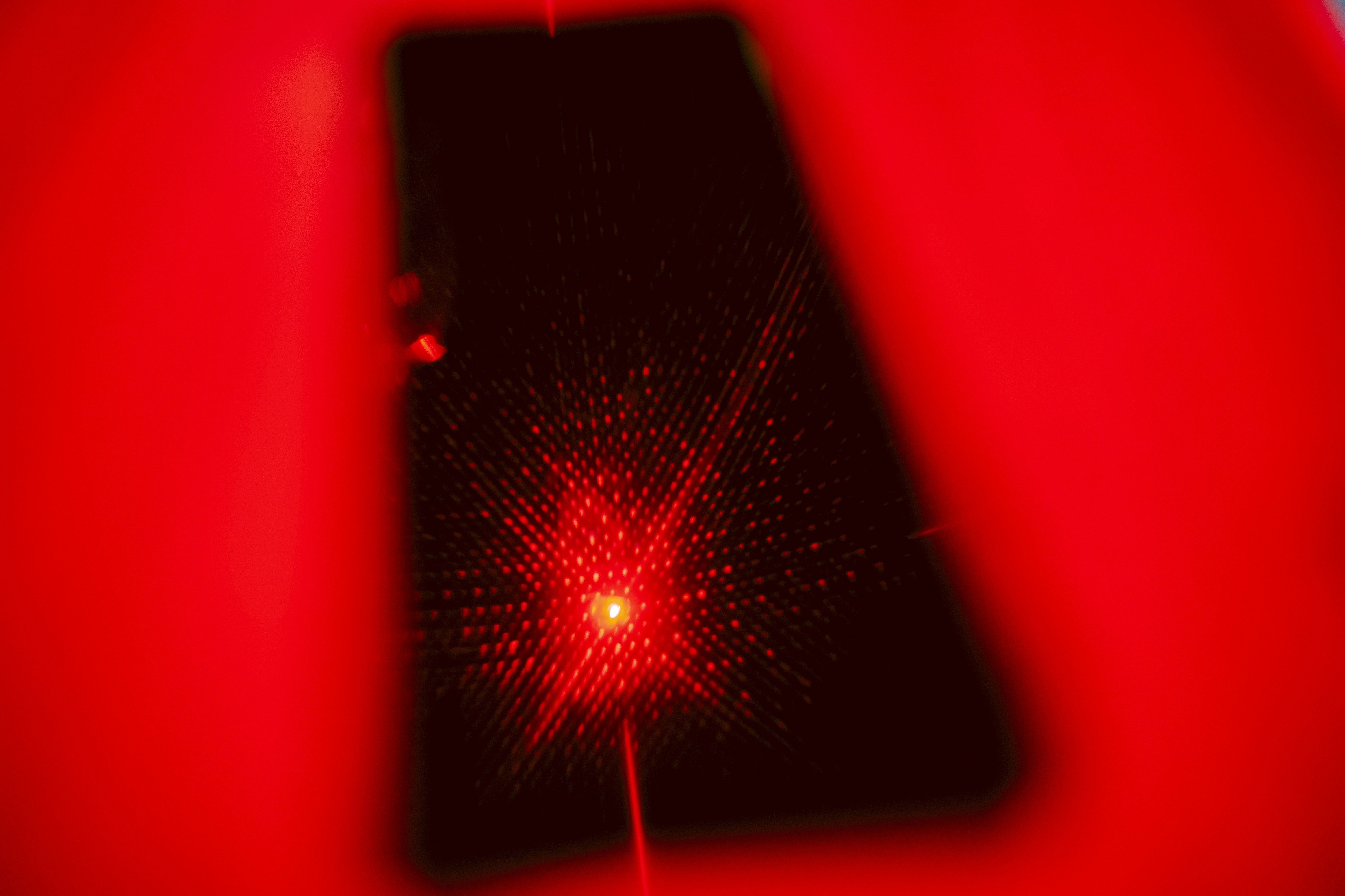 Crimson Laser Bloom on a Dark Smartphone Screen