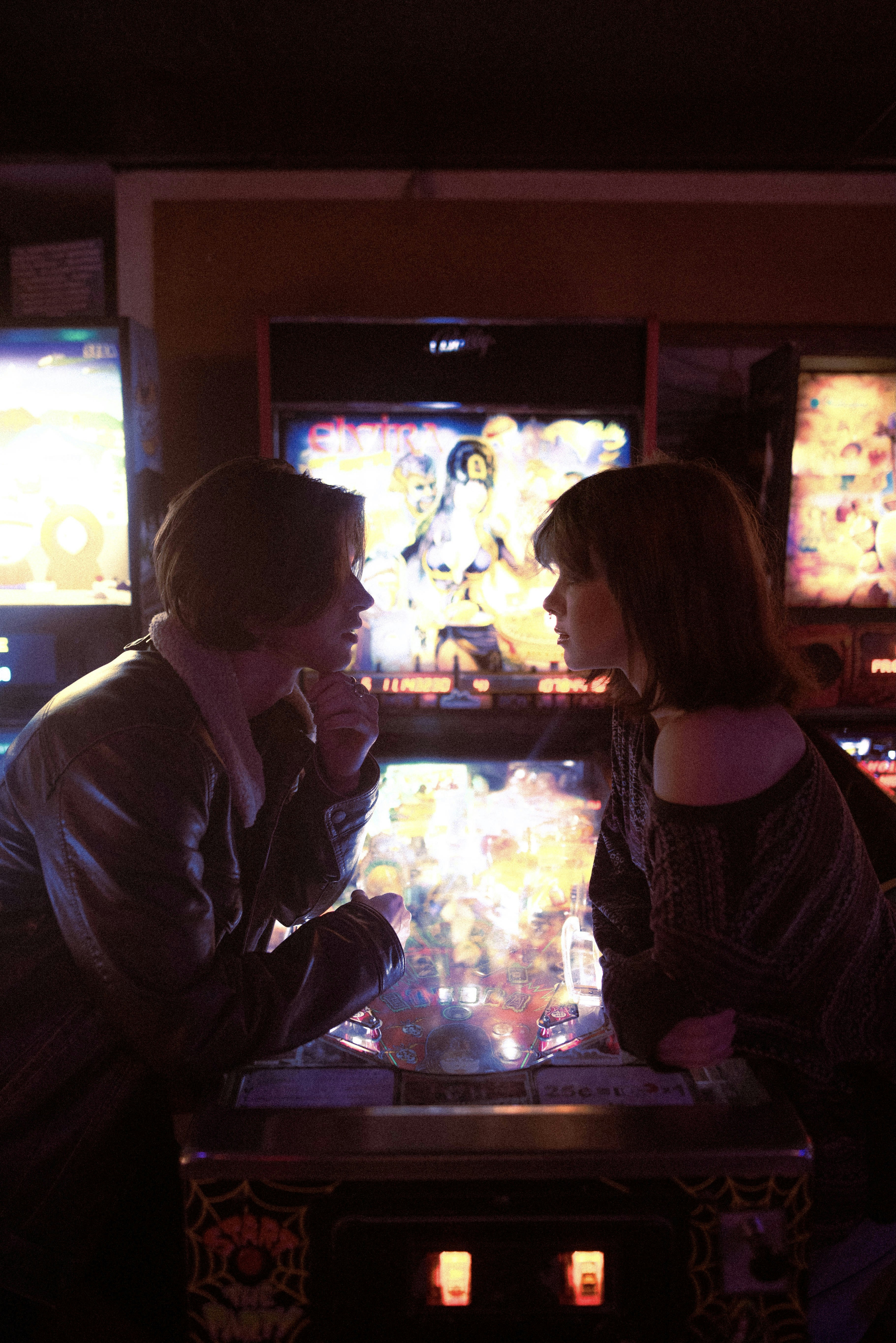 Midnight Arcade Moment: Two Faces Lean in Close Over Neon Reflections