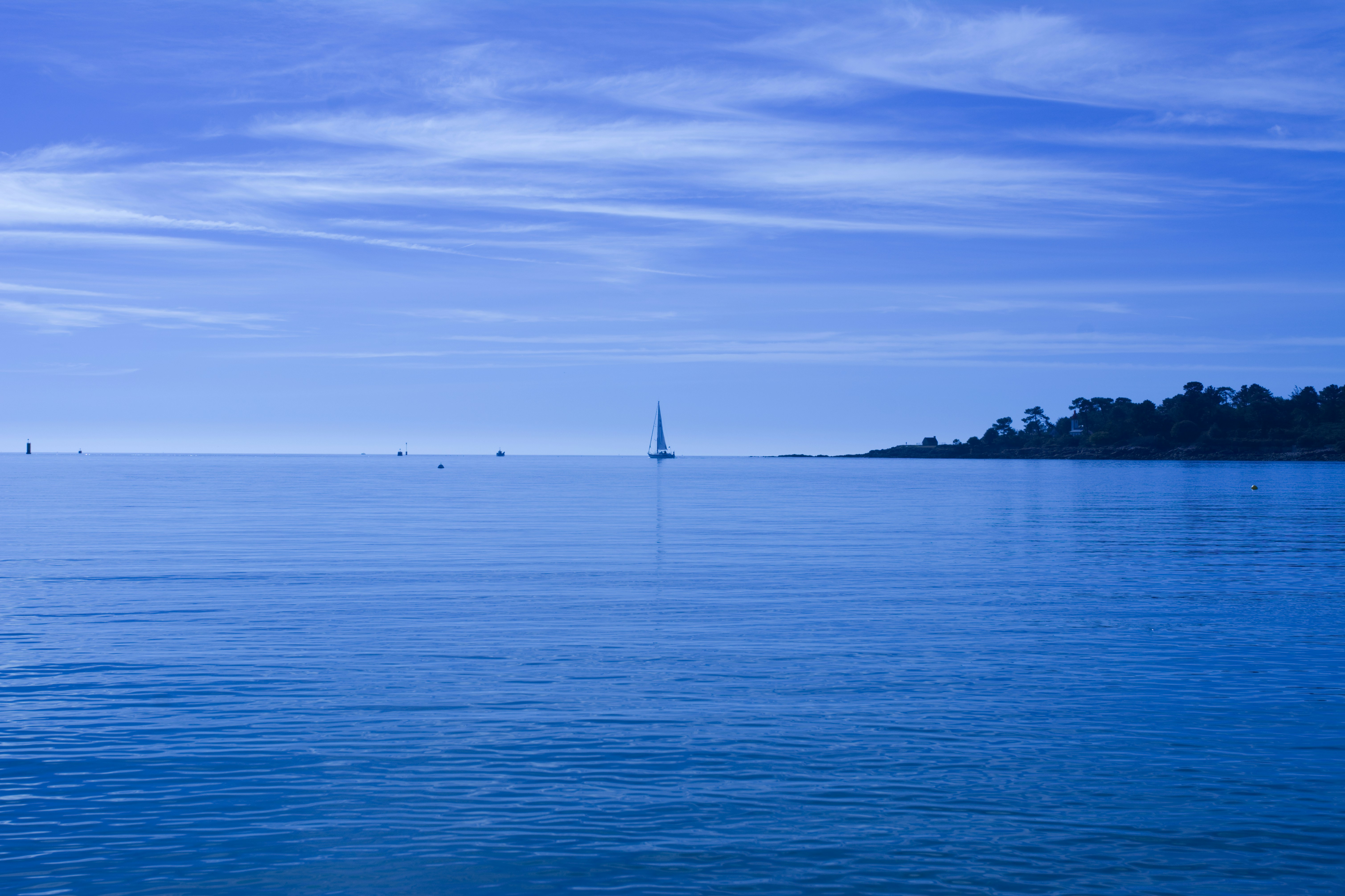 Cerulean Horizon: A Lone Sail Against the Quiet Blue