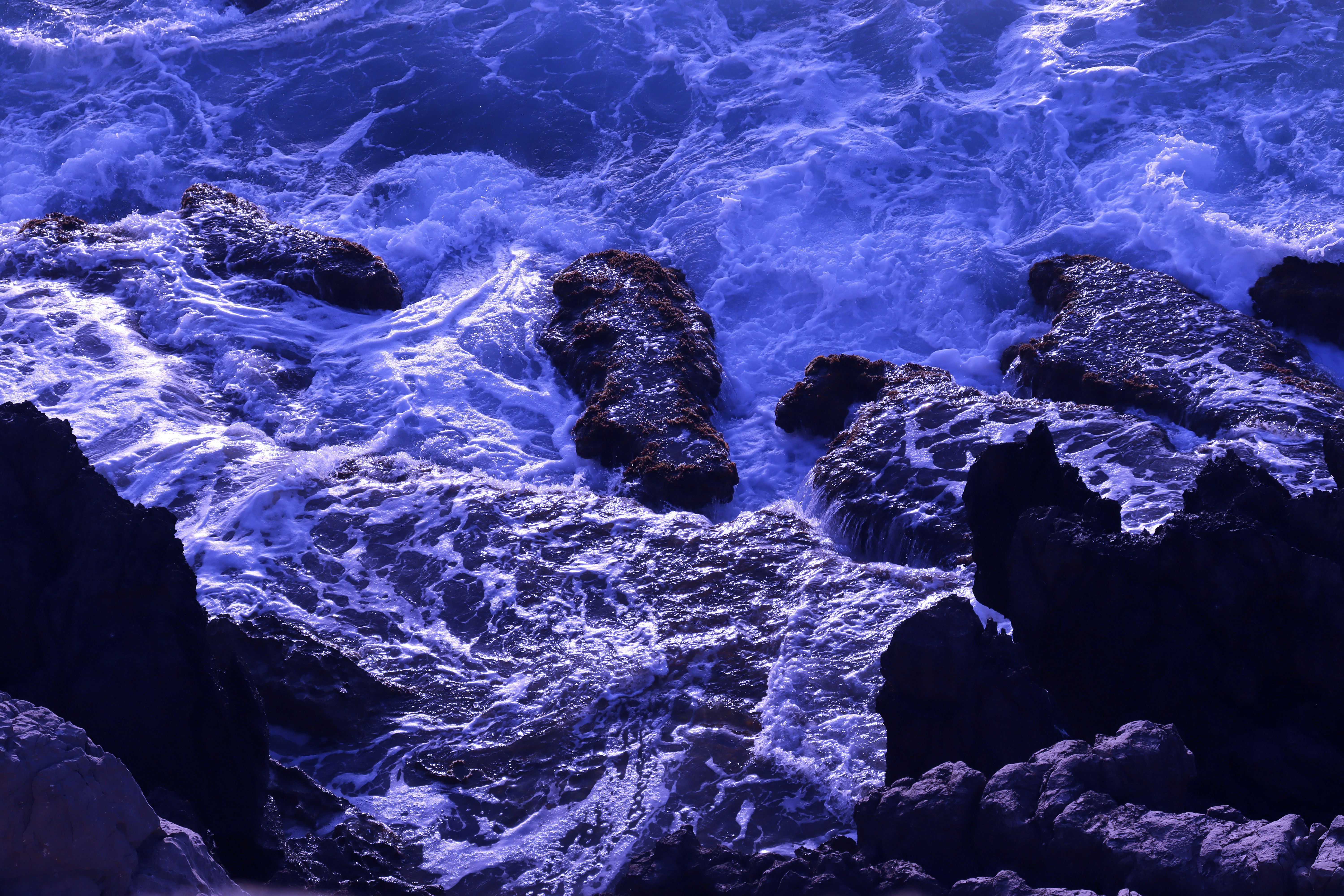 Black rock formation on body of water during daytime photo – Free ...