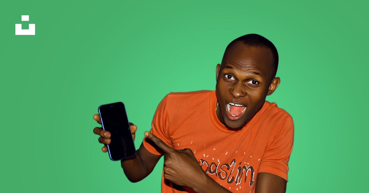オレンジ色のクルーネックtシャツを着た男が黒いスマートフォンを持っているの写真 Unsplashの電話の無料画像