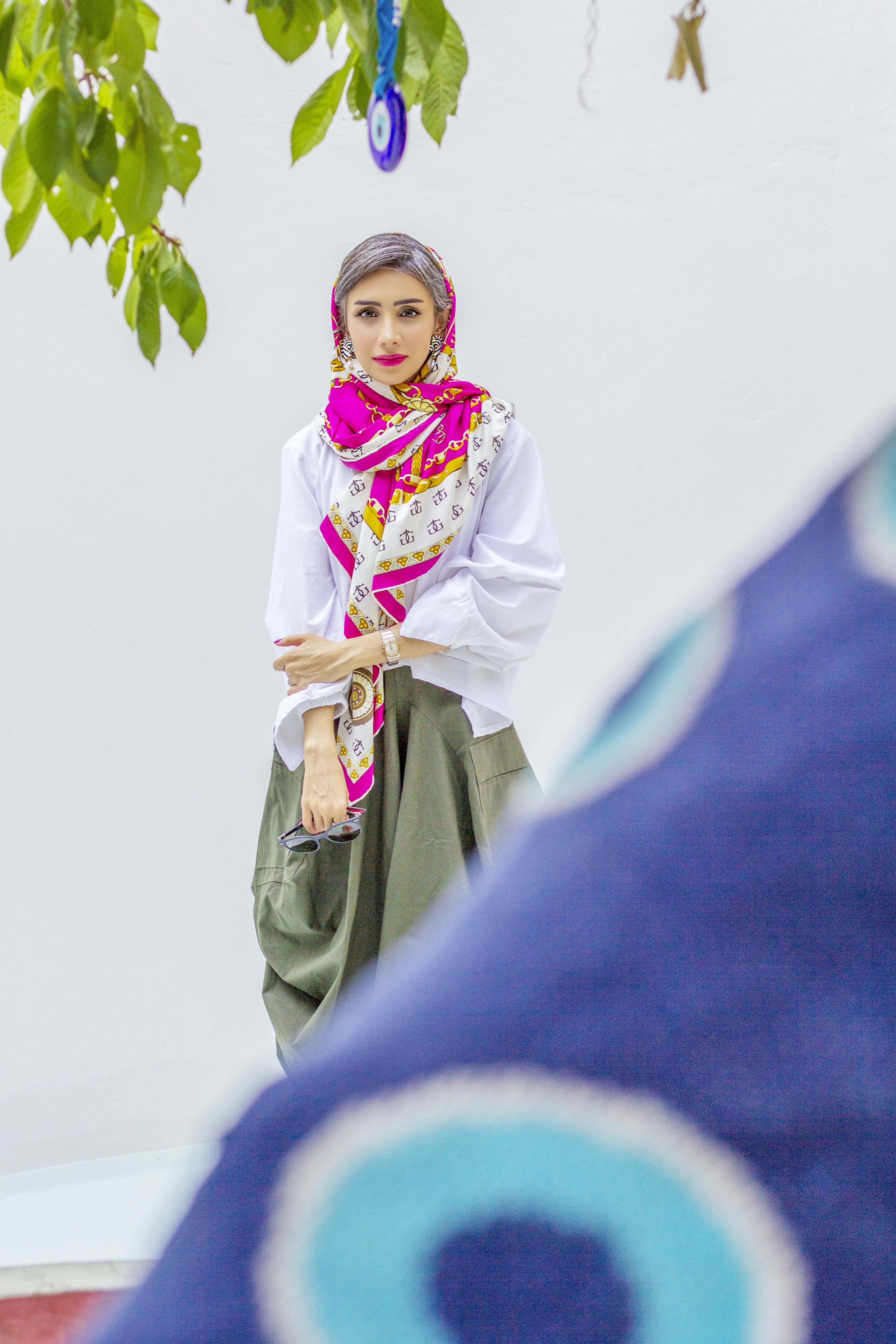Neon Hijab Portrait: Quiet Confidence Under a White Wall