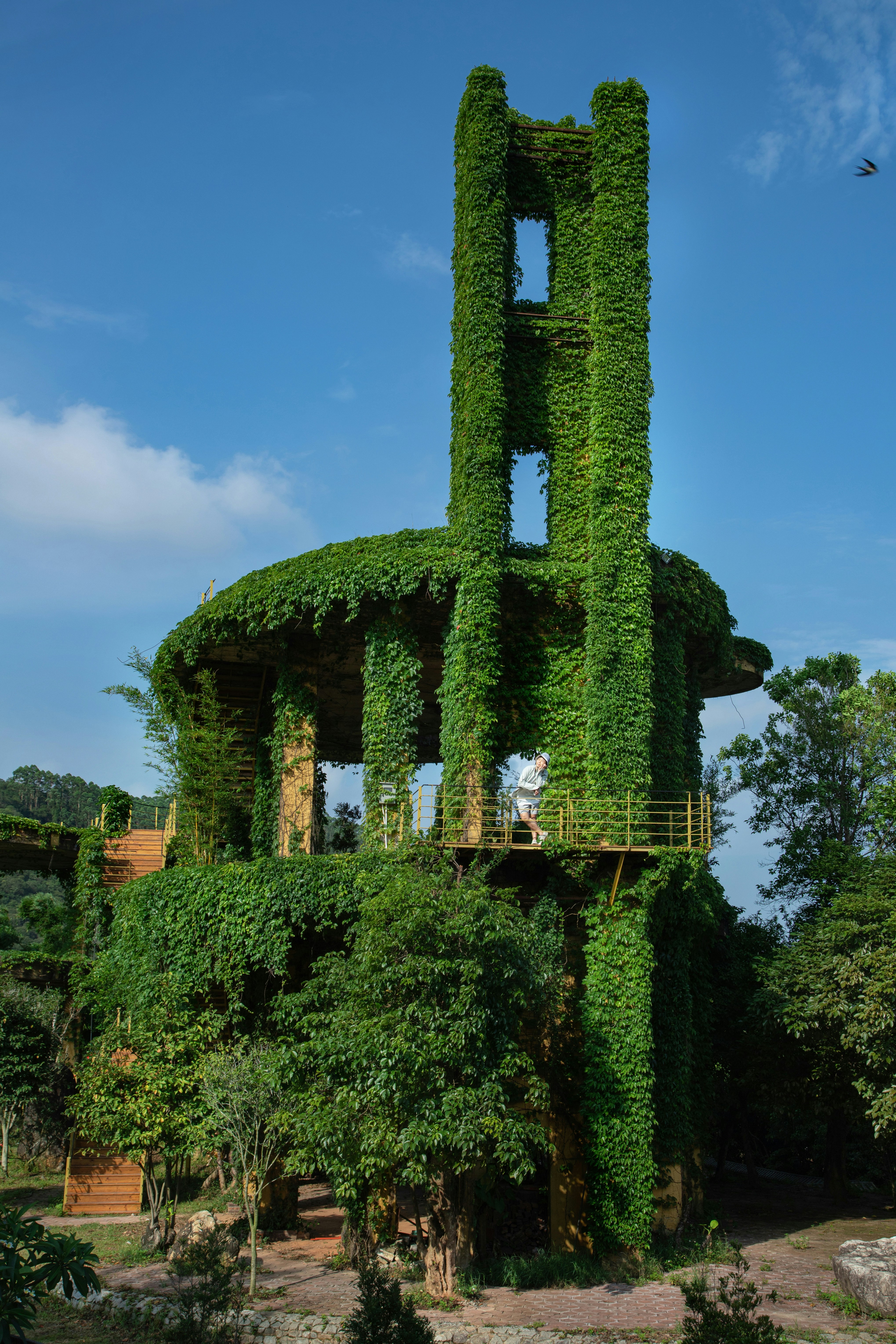 The Ivy-Spired Lookout: A Tower Cloaked in Green Against a Clear Sky