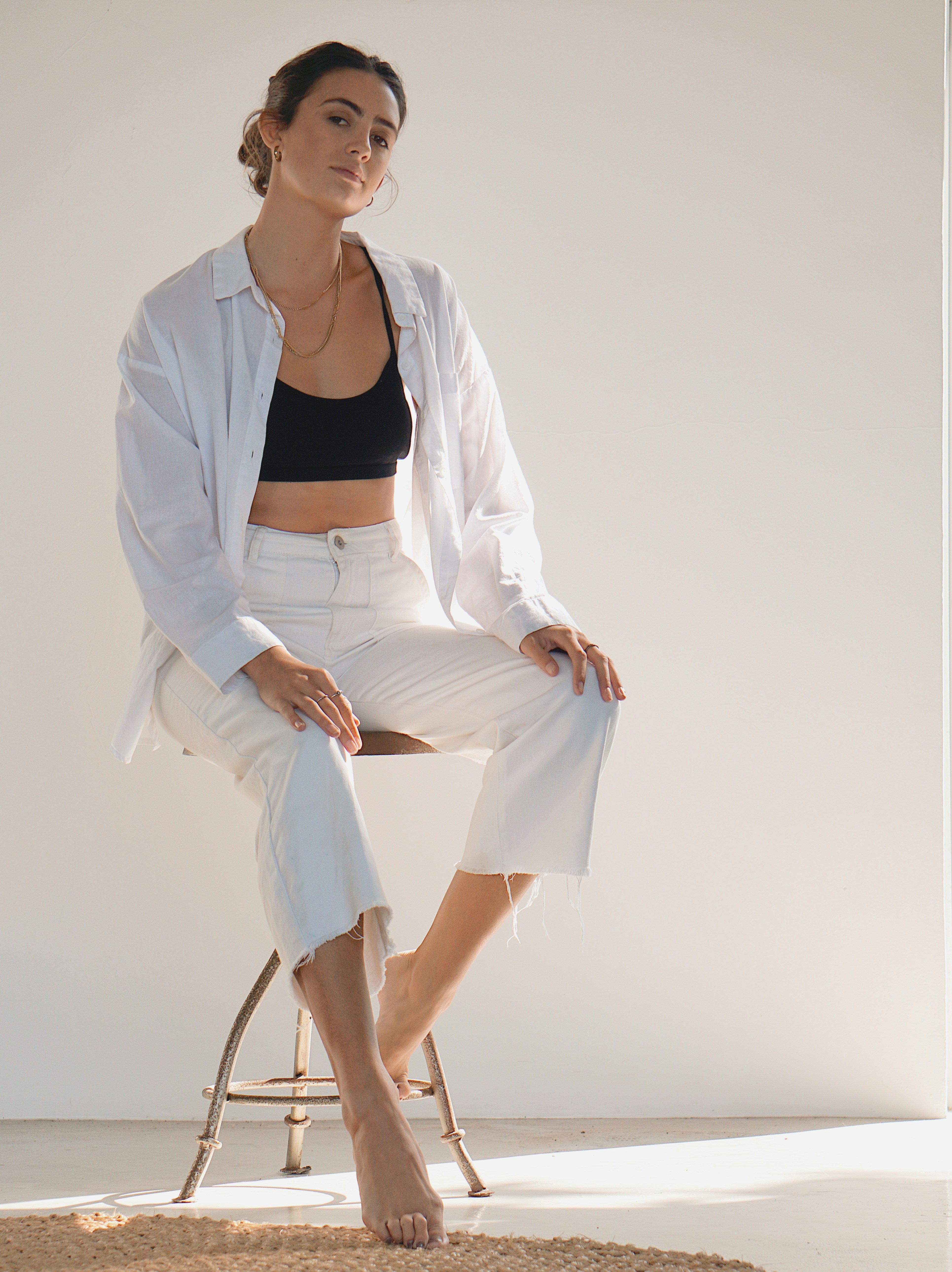 Woman in white blazer and white dress shirt sitting on chair photo ...