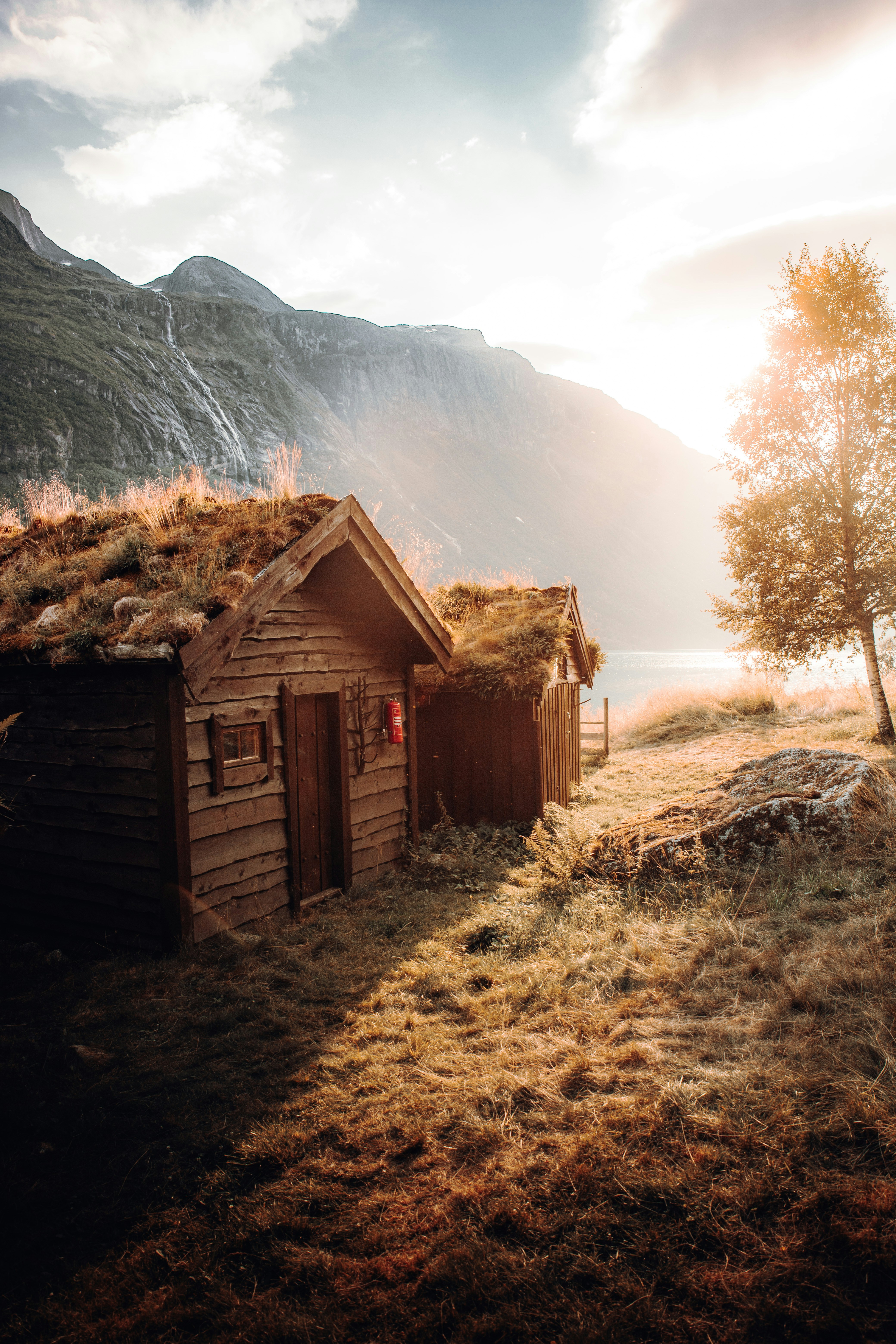 Sunset vibes in Lovatnet! 🌄 | brown wooden house near brown trees and mountain during daytime