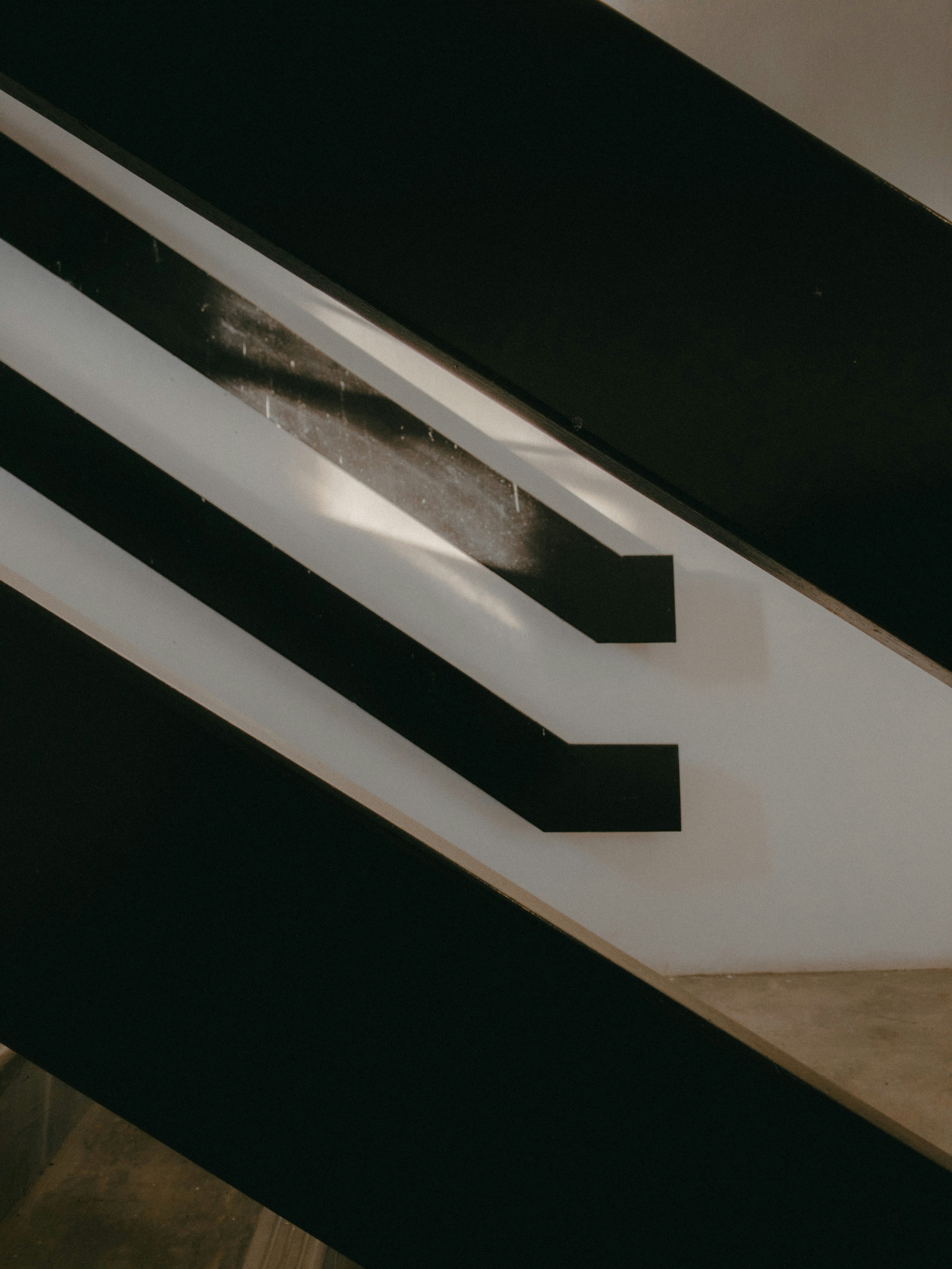 lines across handrail  | a close up of a black and white object on a wall