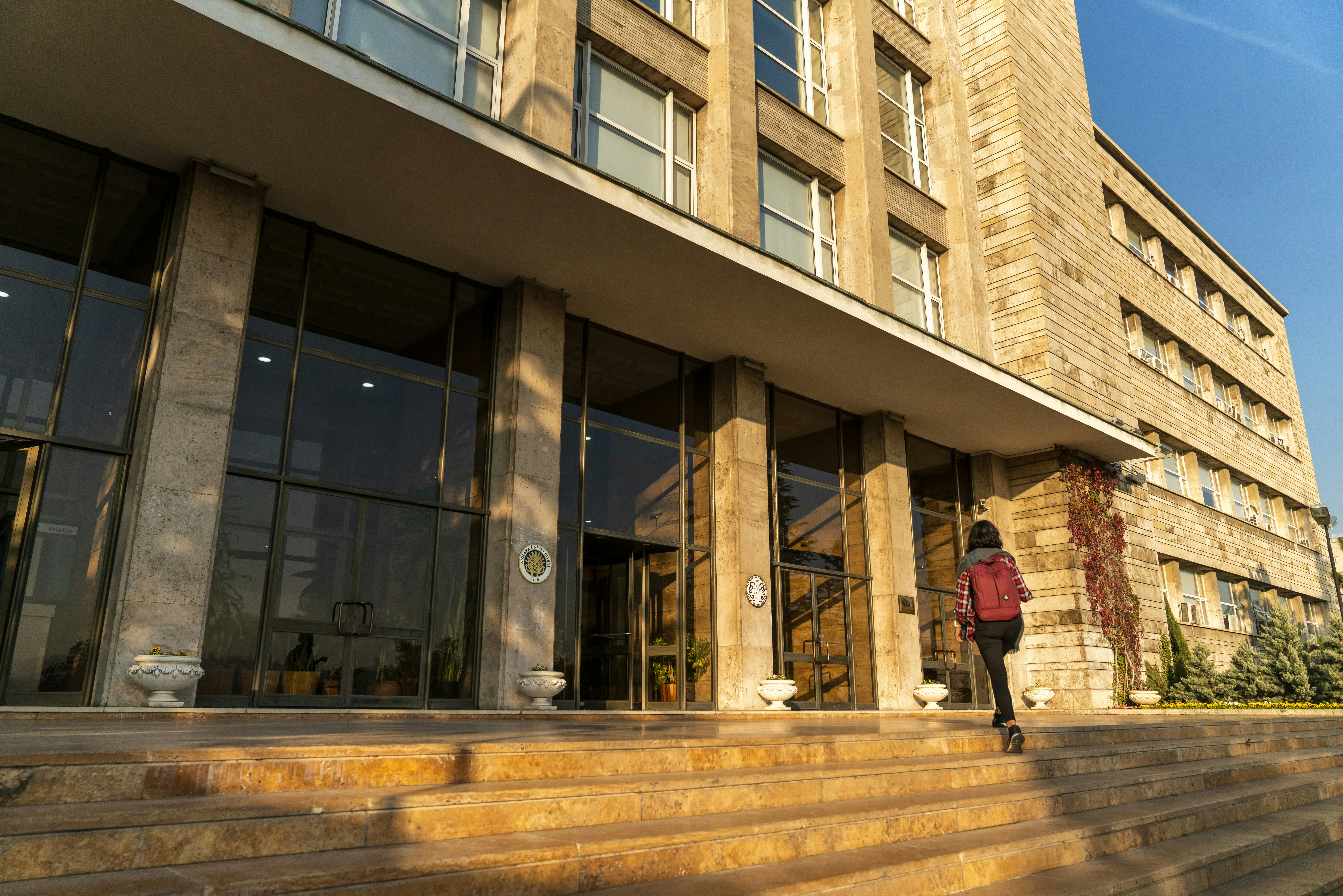 A person walking up some steps in front of a building photo – Free ...