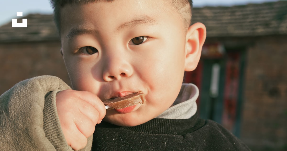 食べ物を食べる黒と白のセーターを着た男の子の写真 Unsplashの無料人写真