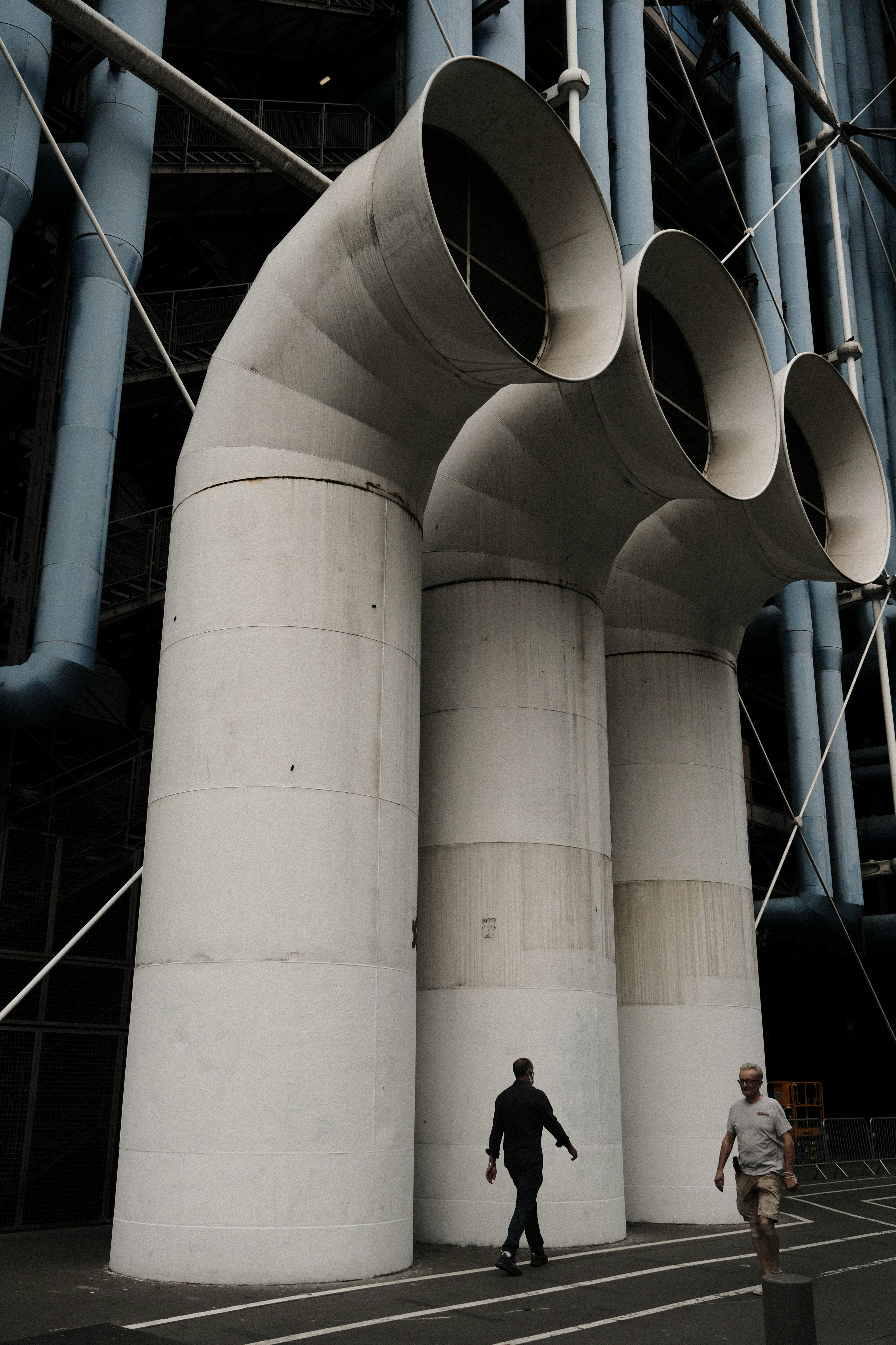 Three Arching Vents: Giants of Steel Framing Two Walkers