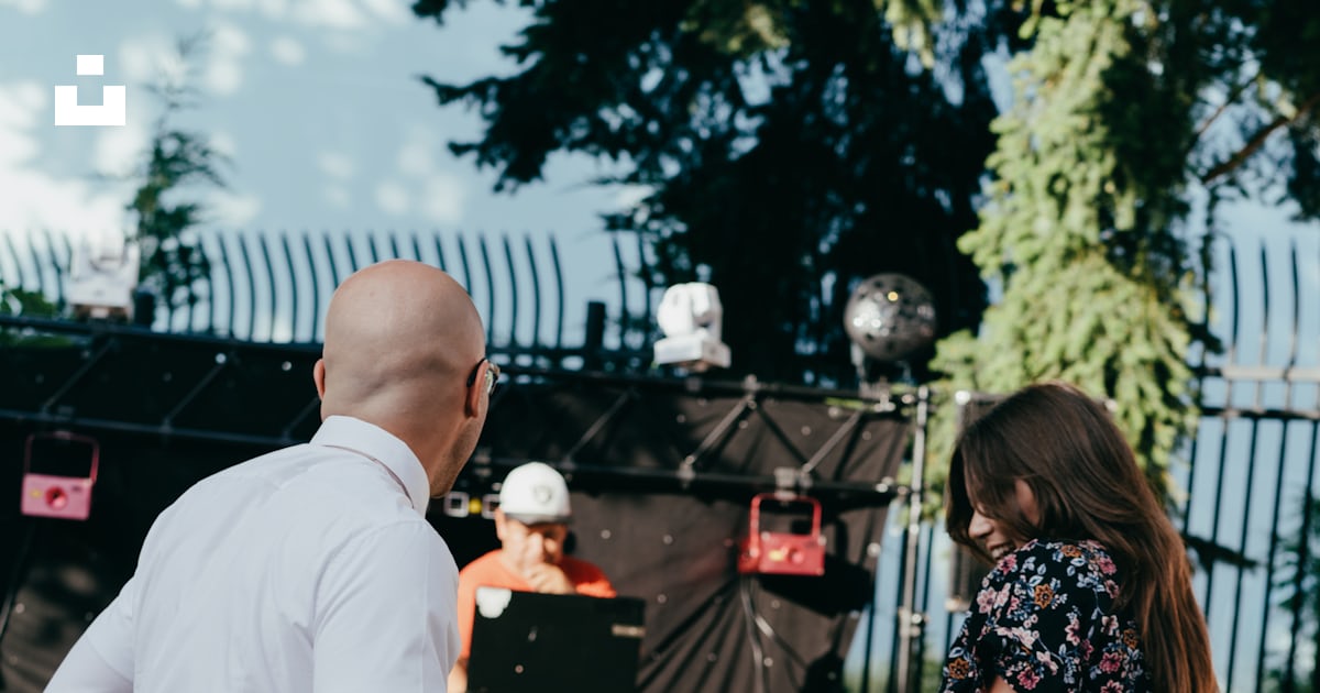 Man In White Long Sleeve Shirt And Black Pants Standing Beside Woman In