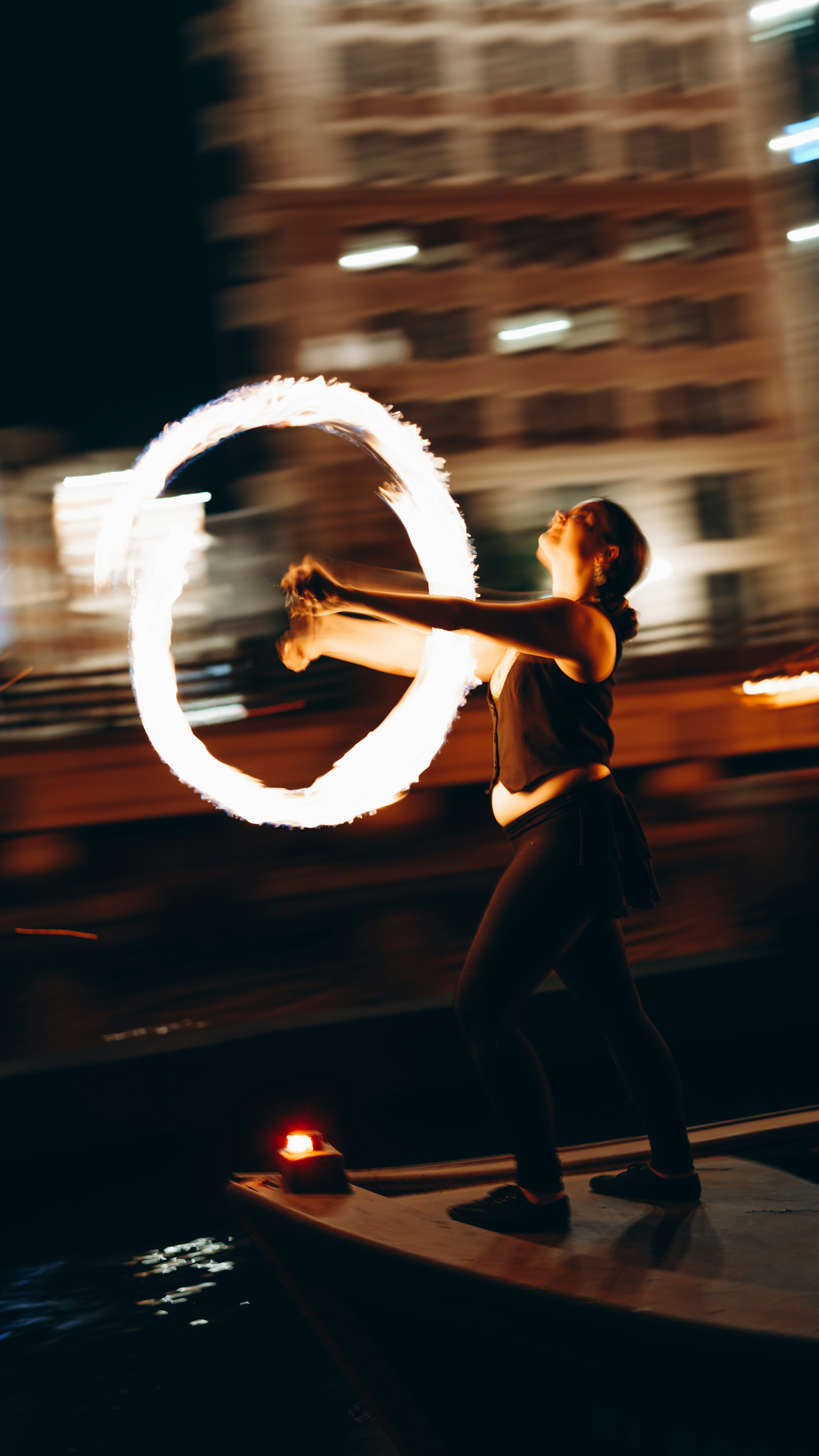 Woman in black tank top and black pants sitting on brown wooden bench ...