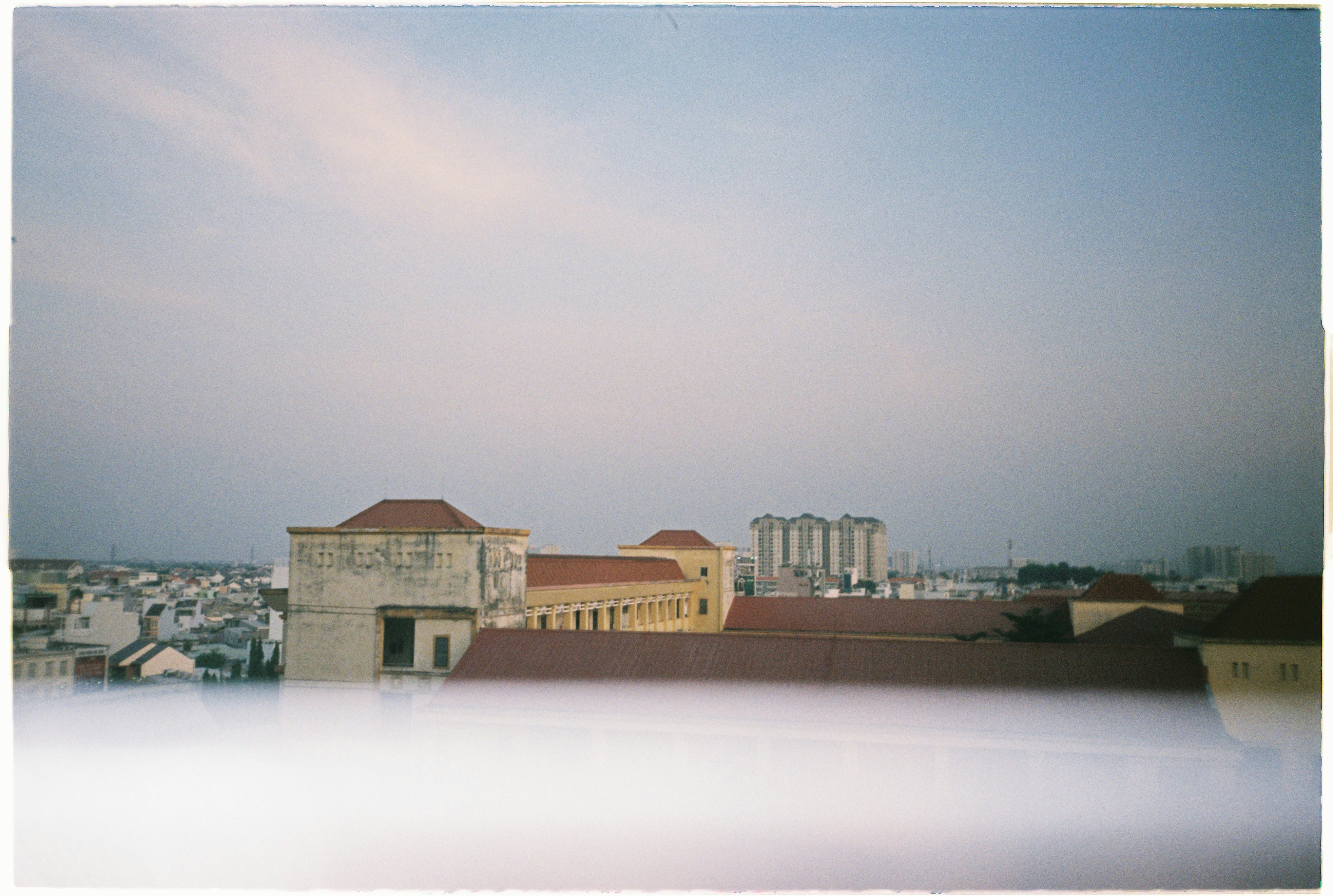 View of a city skyline featuring a mix of architectural styles under a pastel sky at dusk.