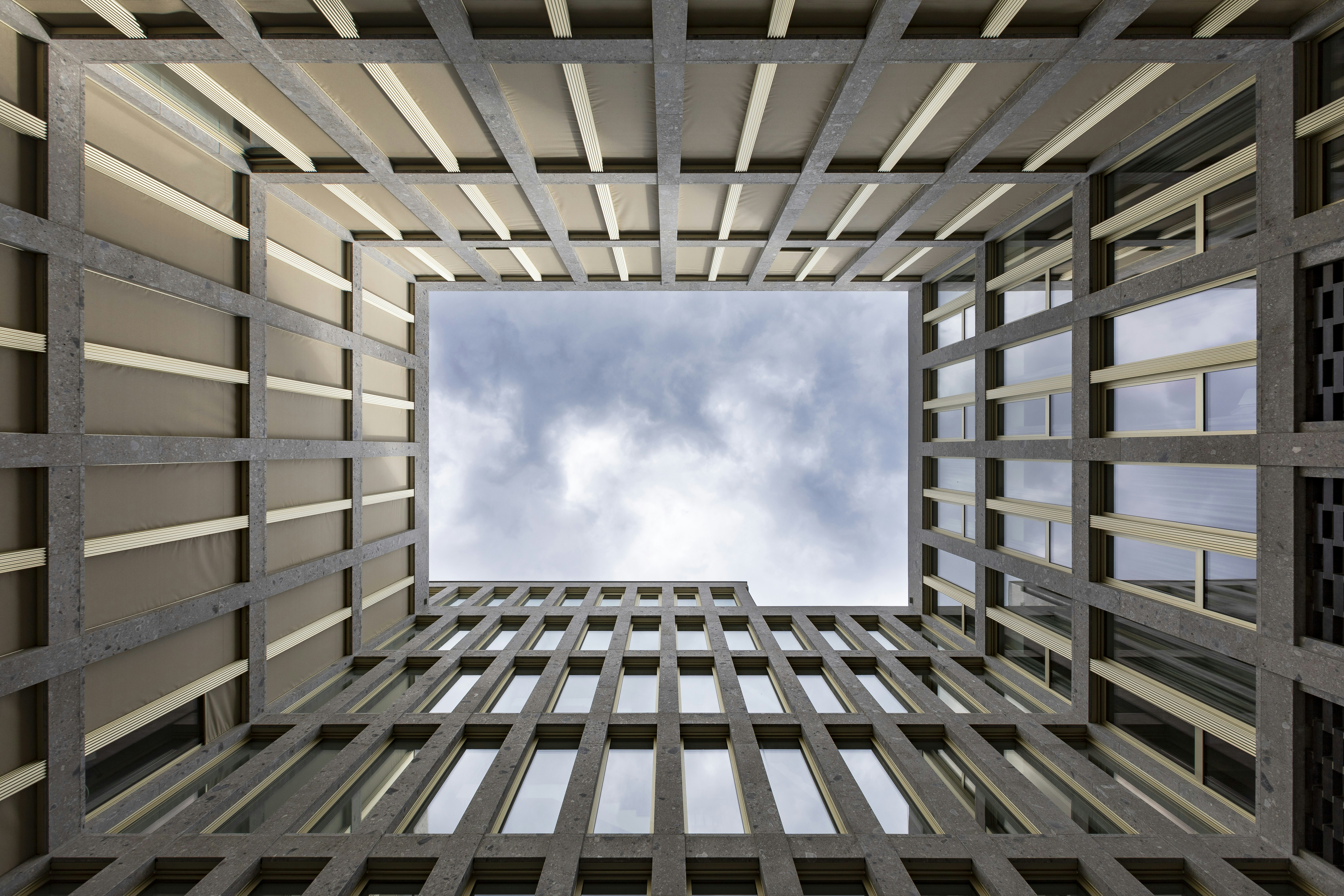 Worms eye view of gray concrete building under cloudy sky during ...