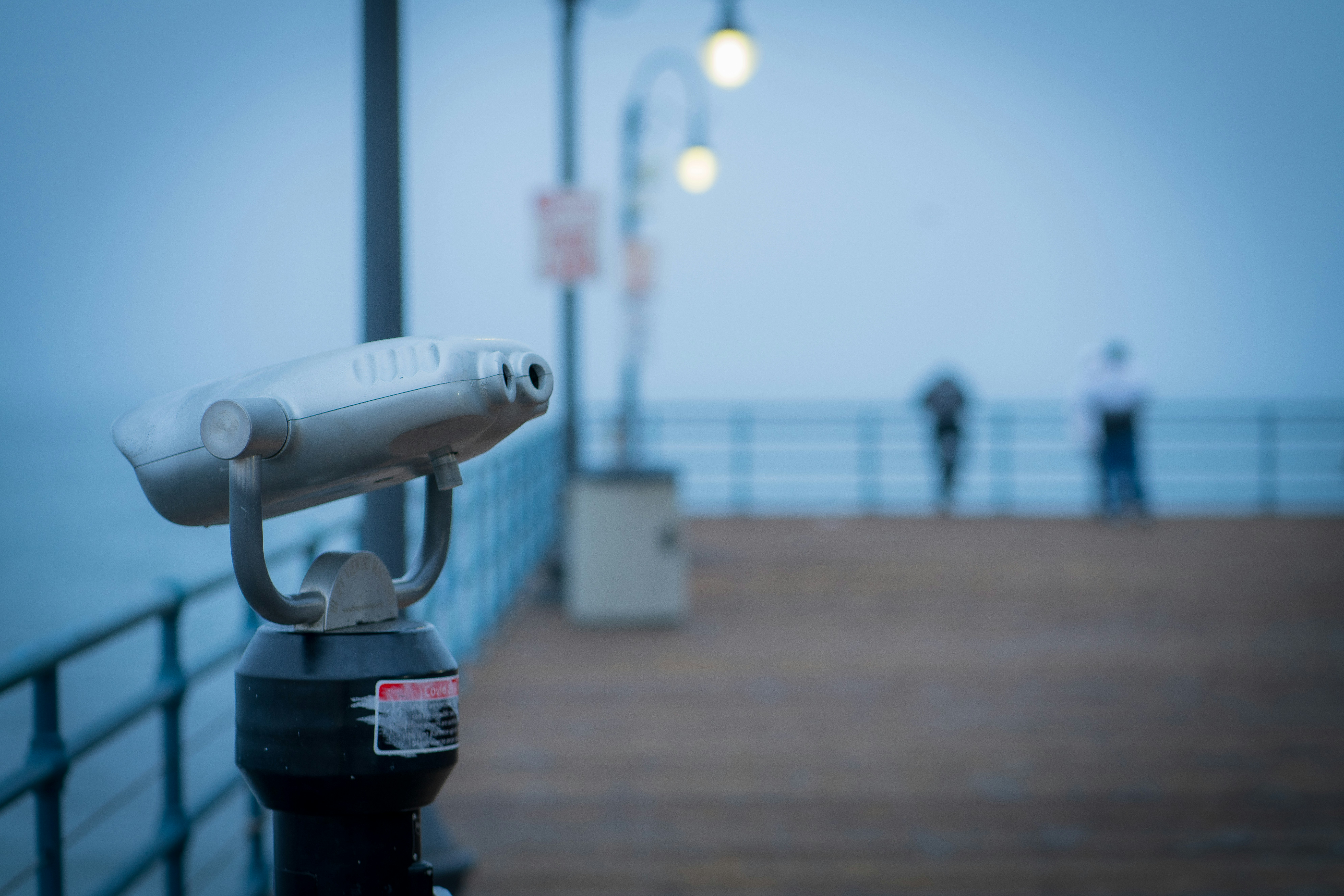 Coastal Viewfinder: A Fisher of Focus on a Seaside Pier