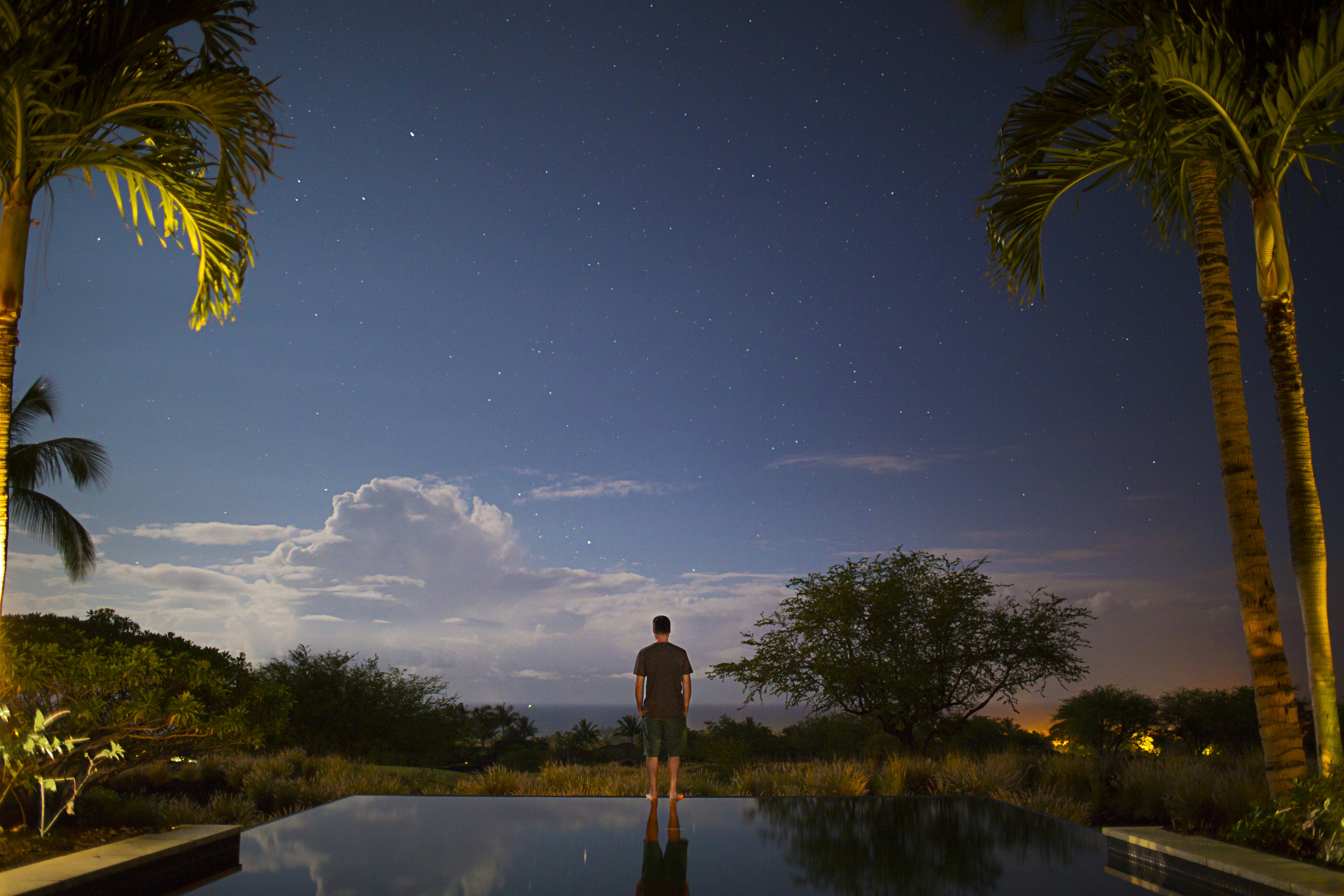 Moonlit Threshold: A Solitary Figure at the Edge of a Quiet Pool