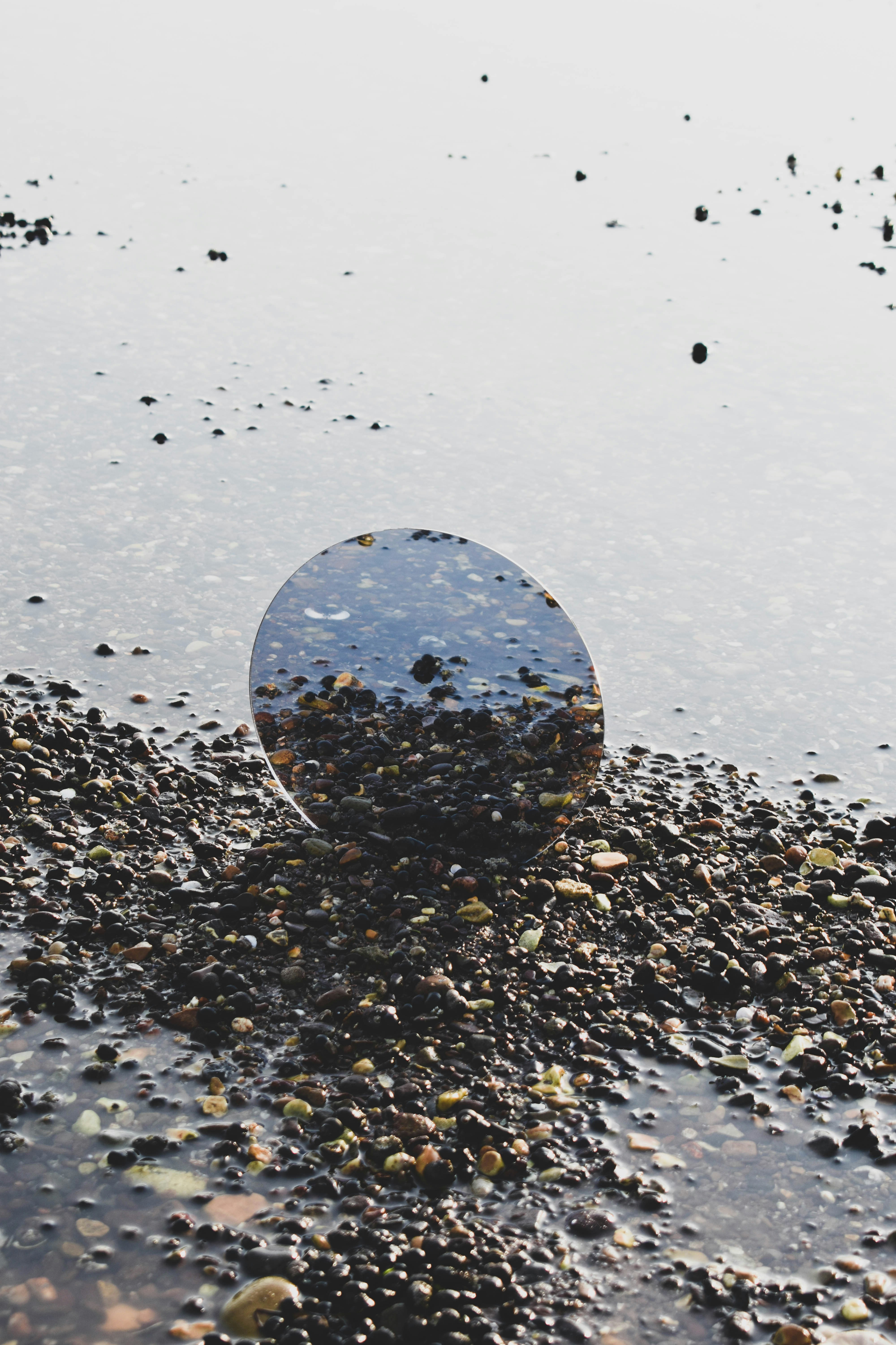 A round object sitting on top of a puddle of water photo – Free United ...