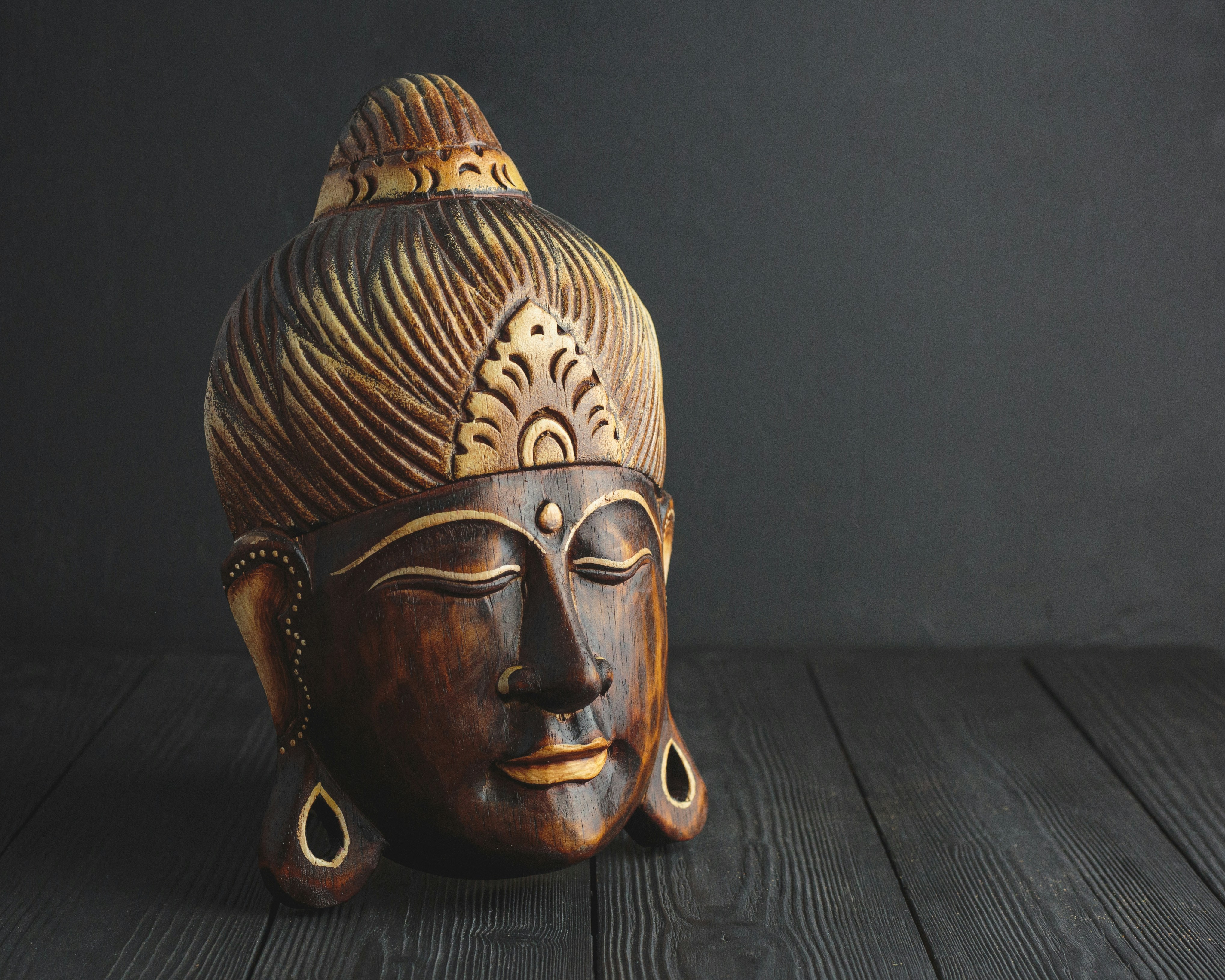 Whispered Serenity: A Hand-Carved Buddha Head on Weathered Planks