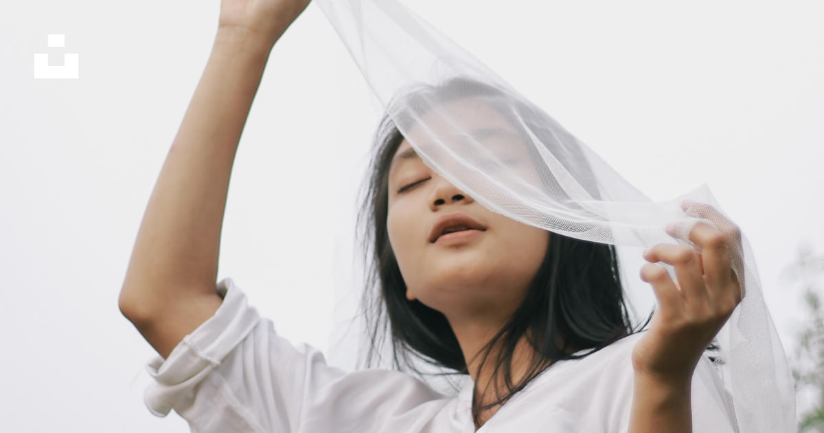 白いヒジャーブをかぶった女性が白い薄手の布で顔を覆うの写真 Unsplashの衣服の無料画像