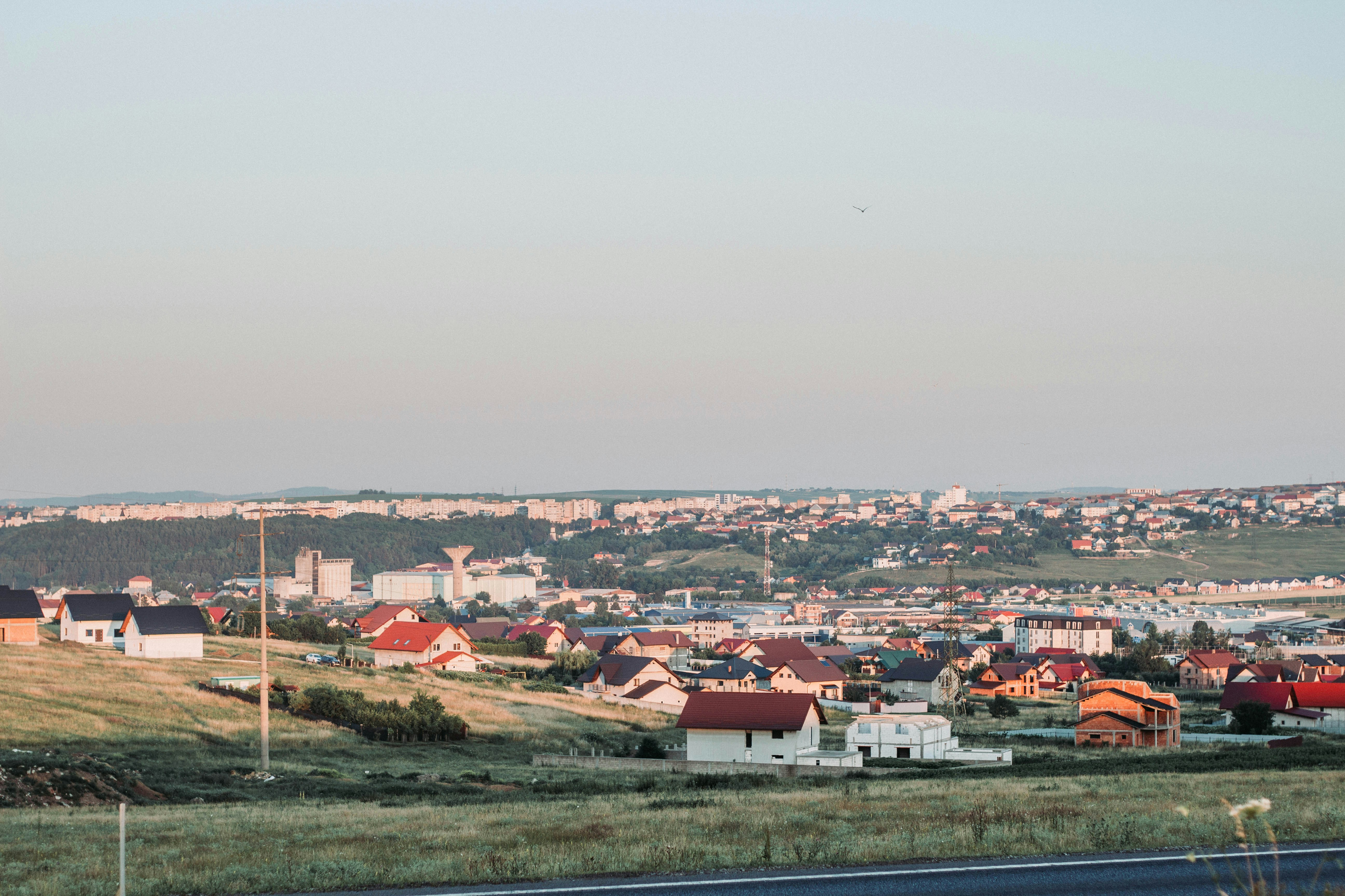 Suburban landscape with colorful rooftops under a clear morning sky.