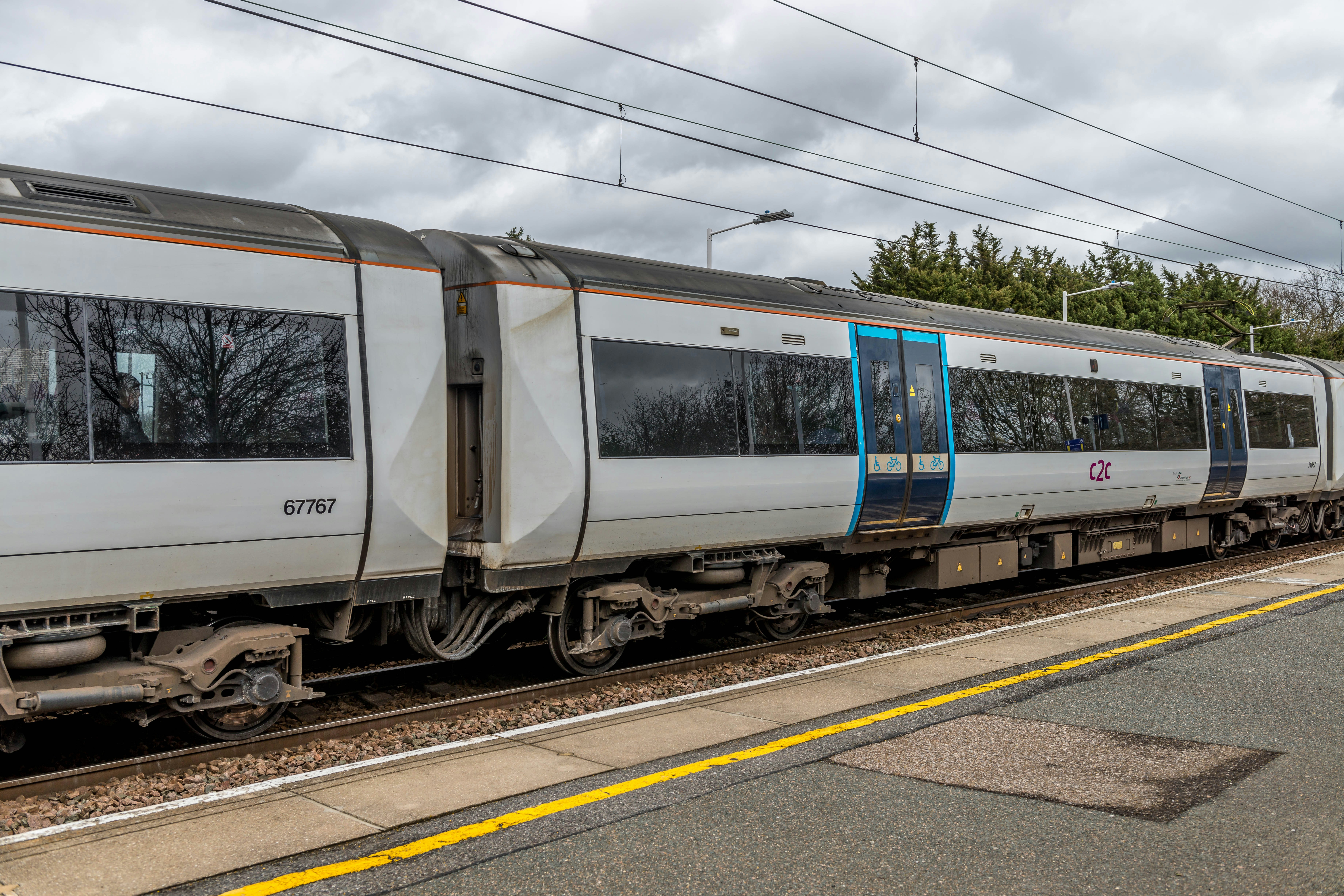 White and blue train on rail tracks under white clouds during daytime ...