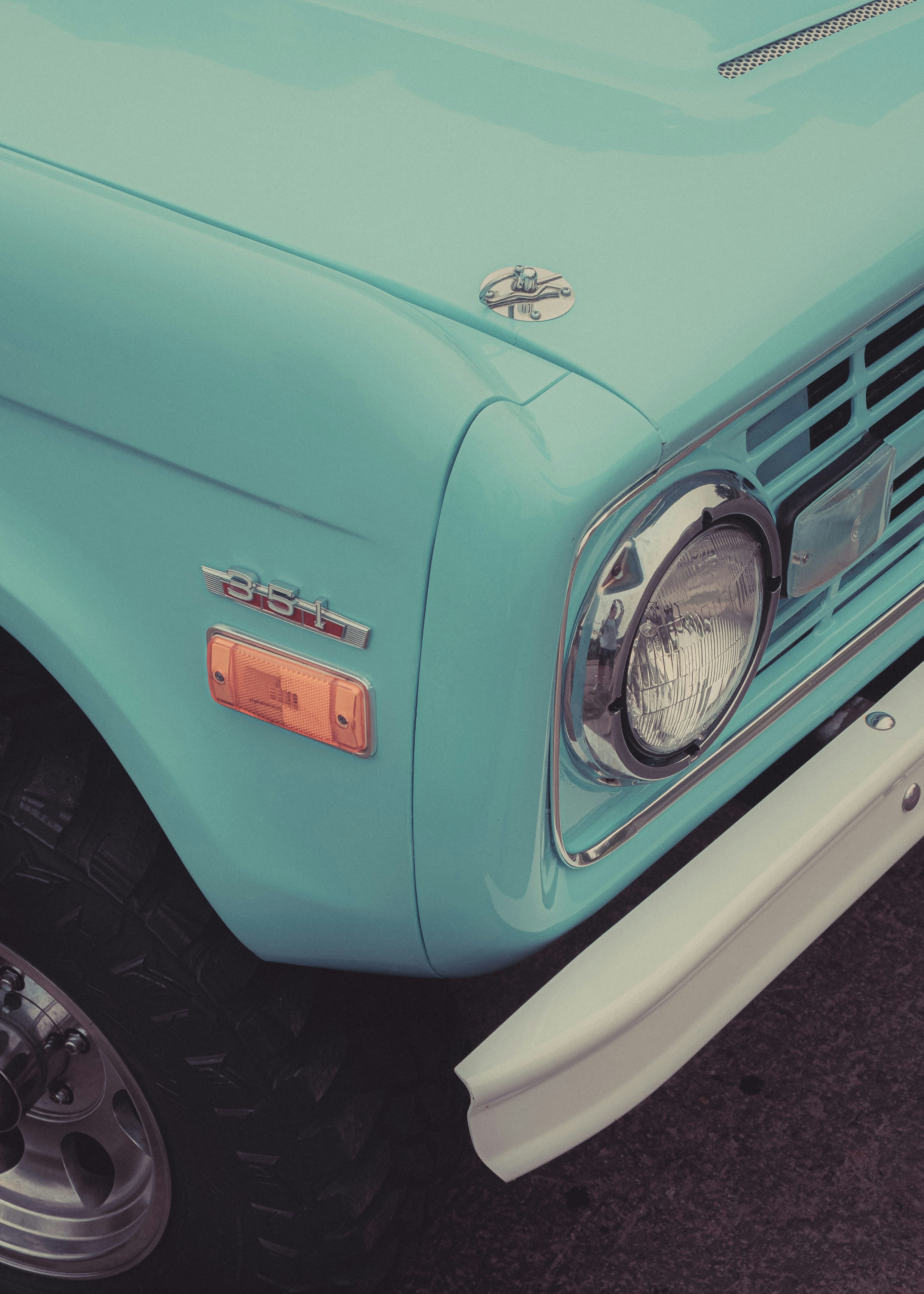 Close-up of a vintage turquoise SUV showcasing its iconic design elements and chrome accents.