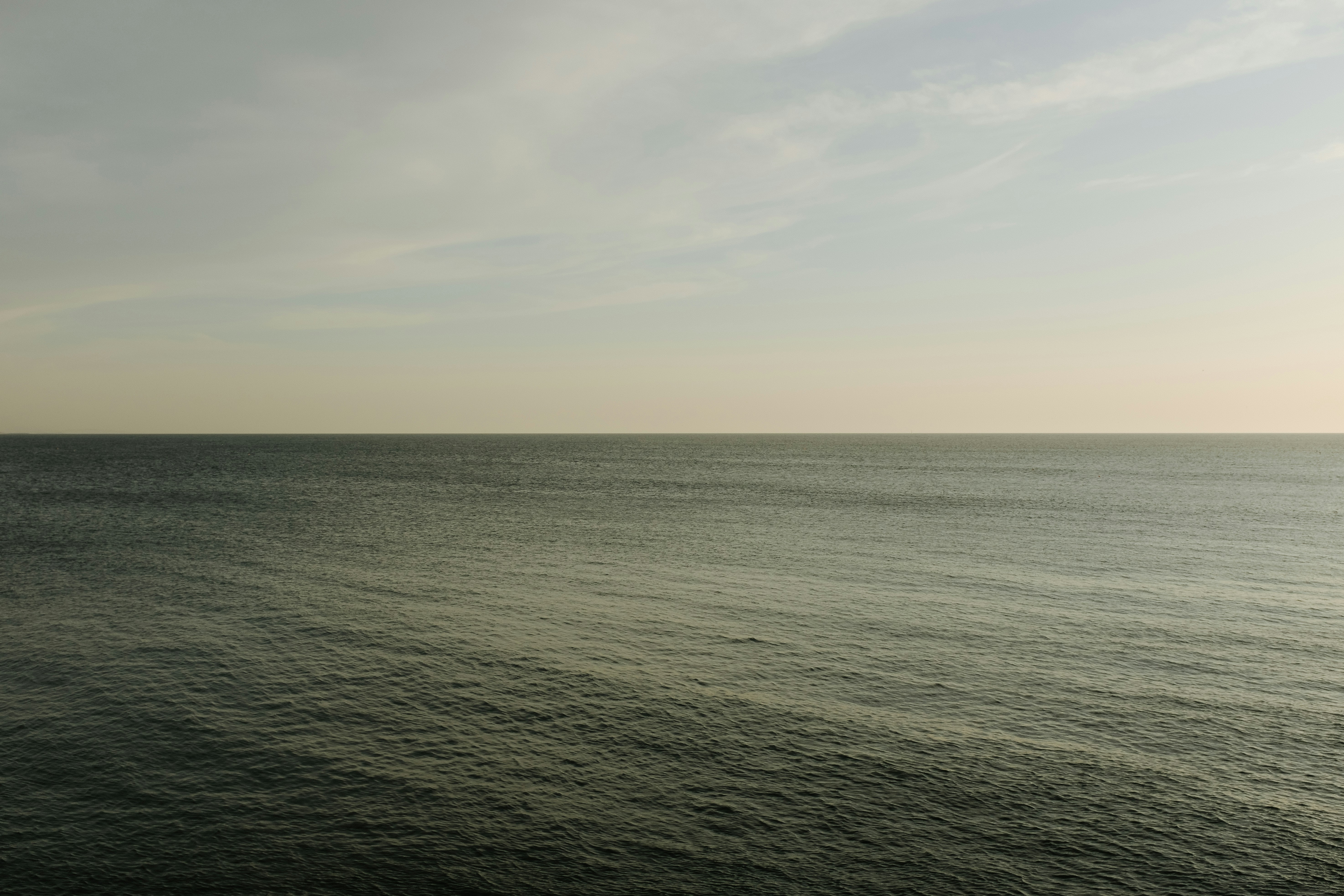 Calm sea under a soft sky, showcasing the serene transition between water and atmosphere.