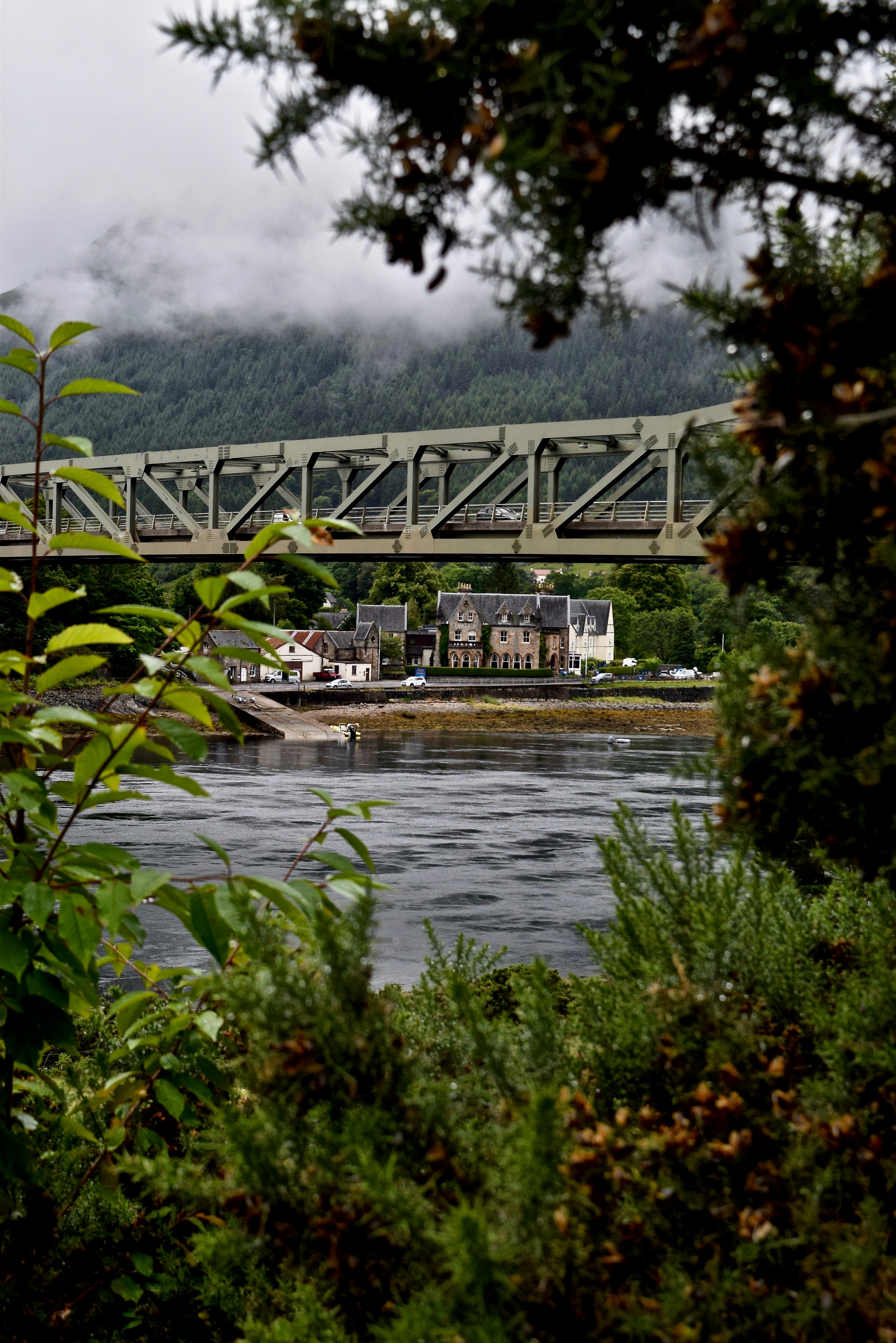 Arched Steel Over Quiet Waters: A Highland Village Under Mist