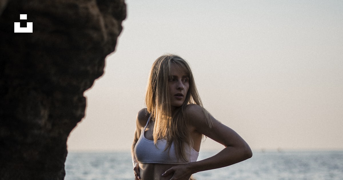 Woman In White Bikini Standing On Rock Near Sea During Daytime Photo