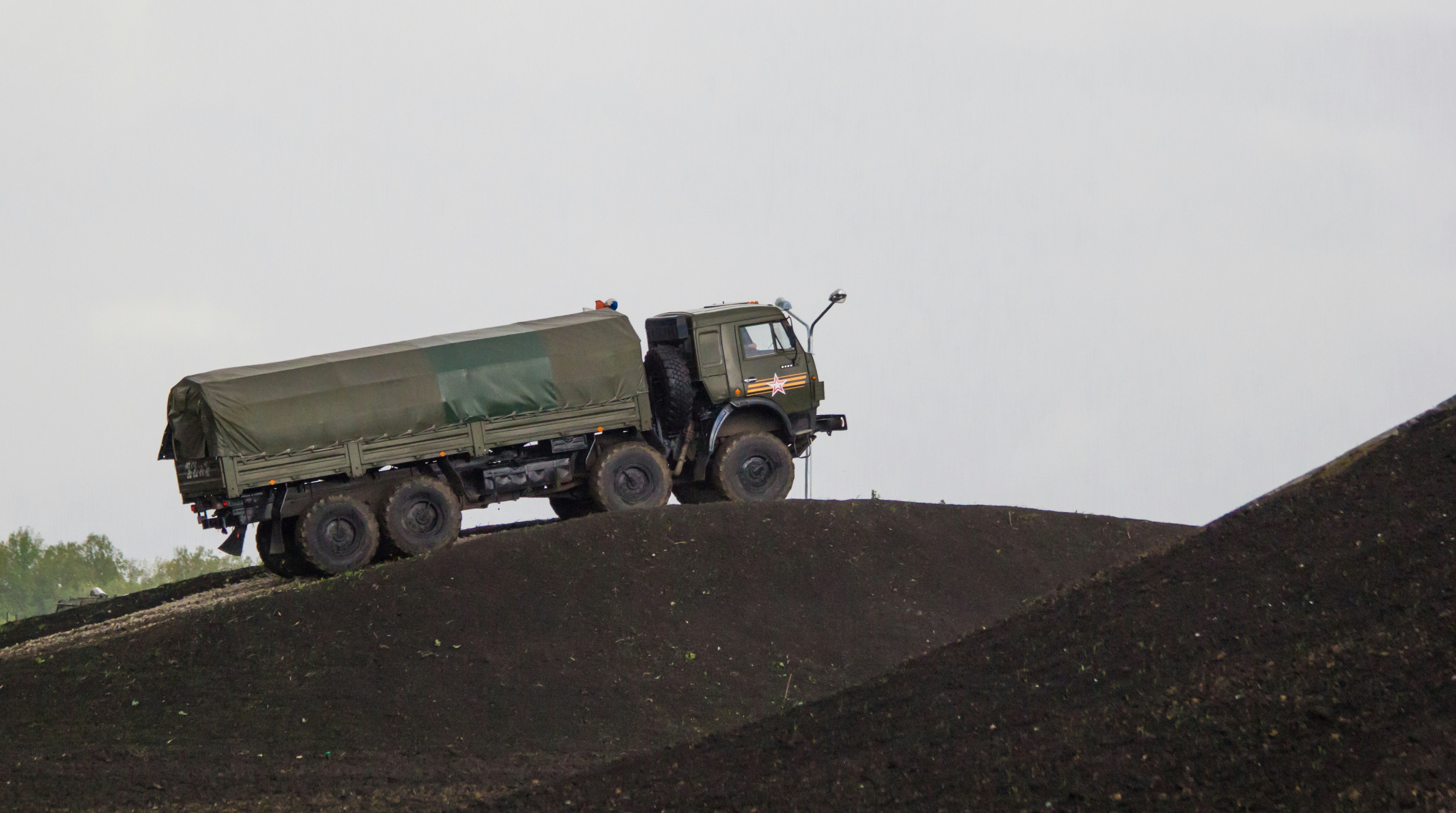 Coal Hill Climber: rugged truck ascends a dark embankment under a quiet sky