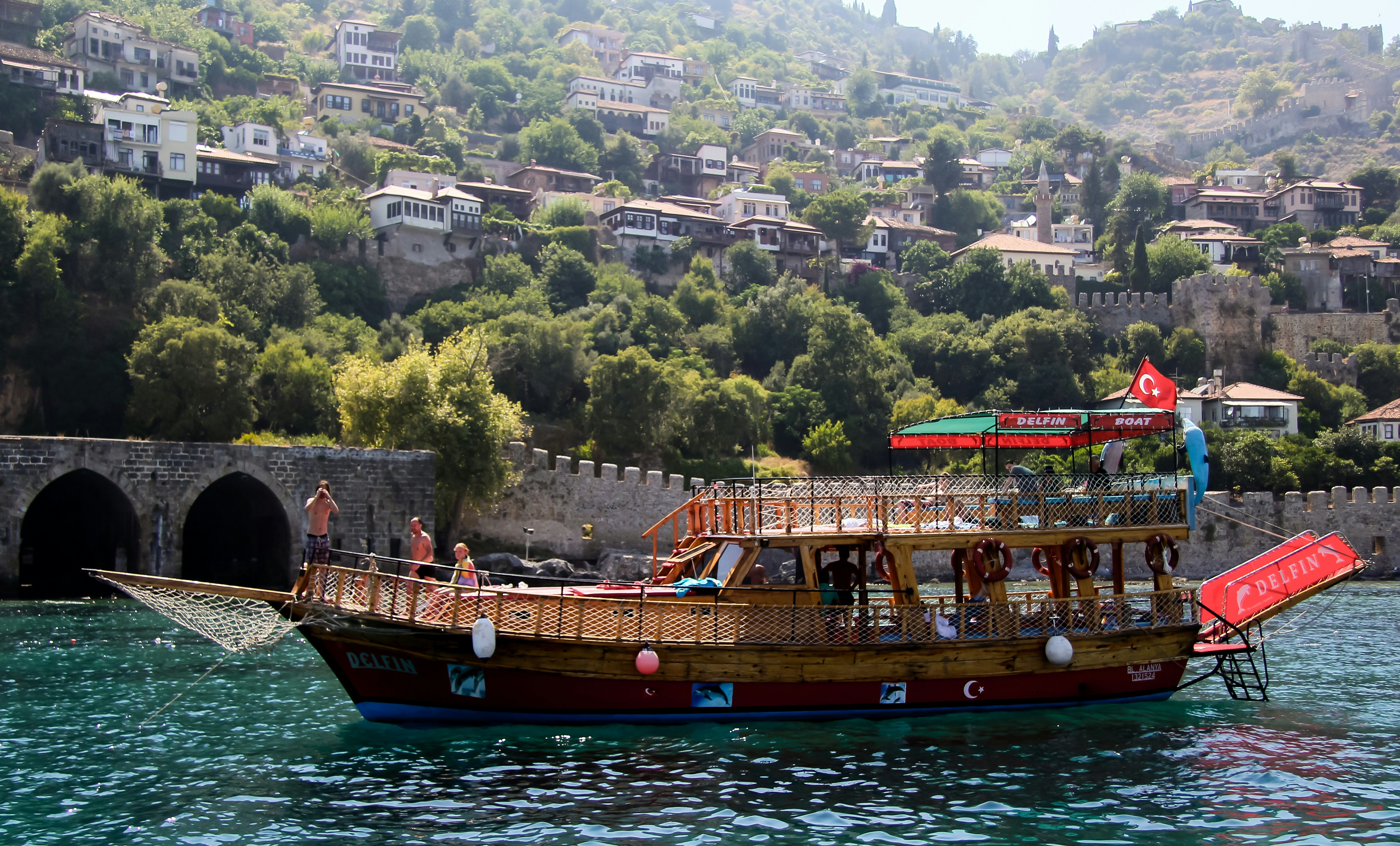 people riding on brown boat on body of water during daytime