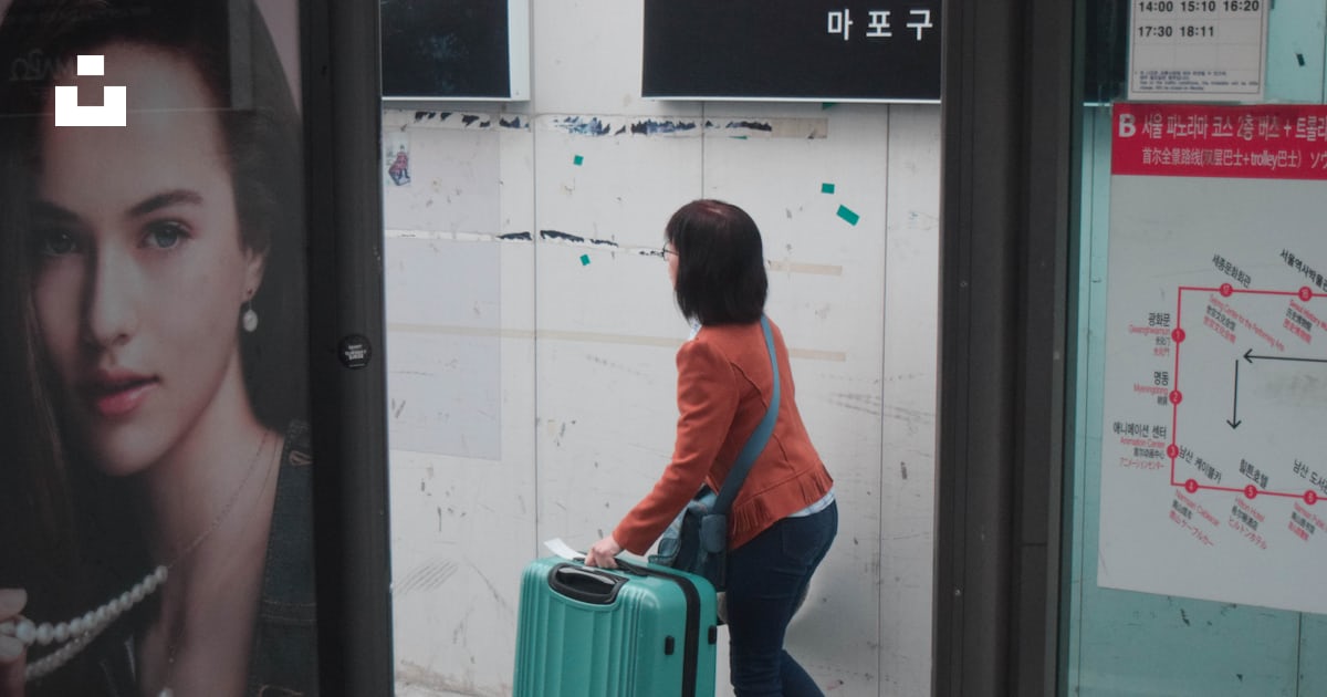 주황색 셔츠와 파란색 데님 청바지를 입은 남자가 녹색 쓰레기통 옆에 서 있다 사진 Unsplash의 무료 서울 이미지