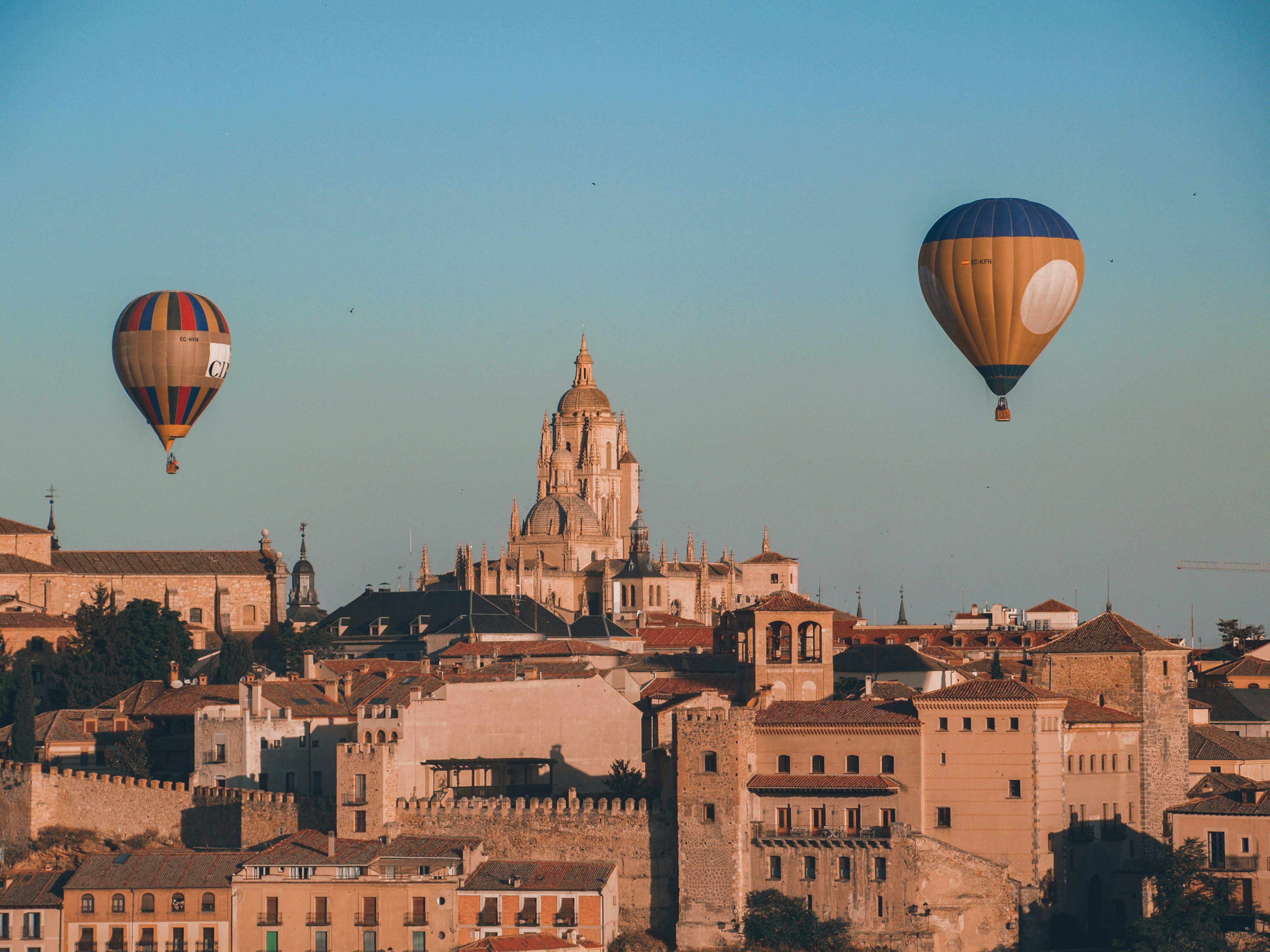 hot air balloons flying over city buildings during daytime
